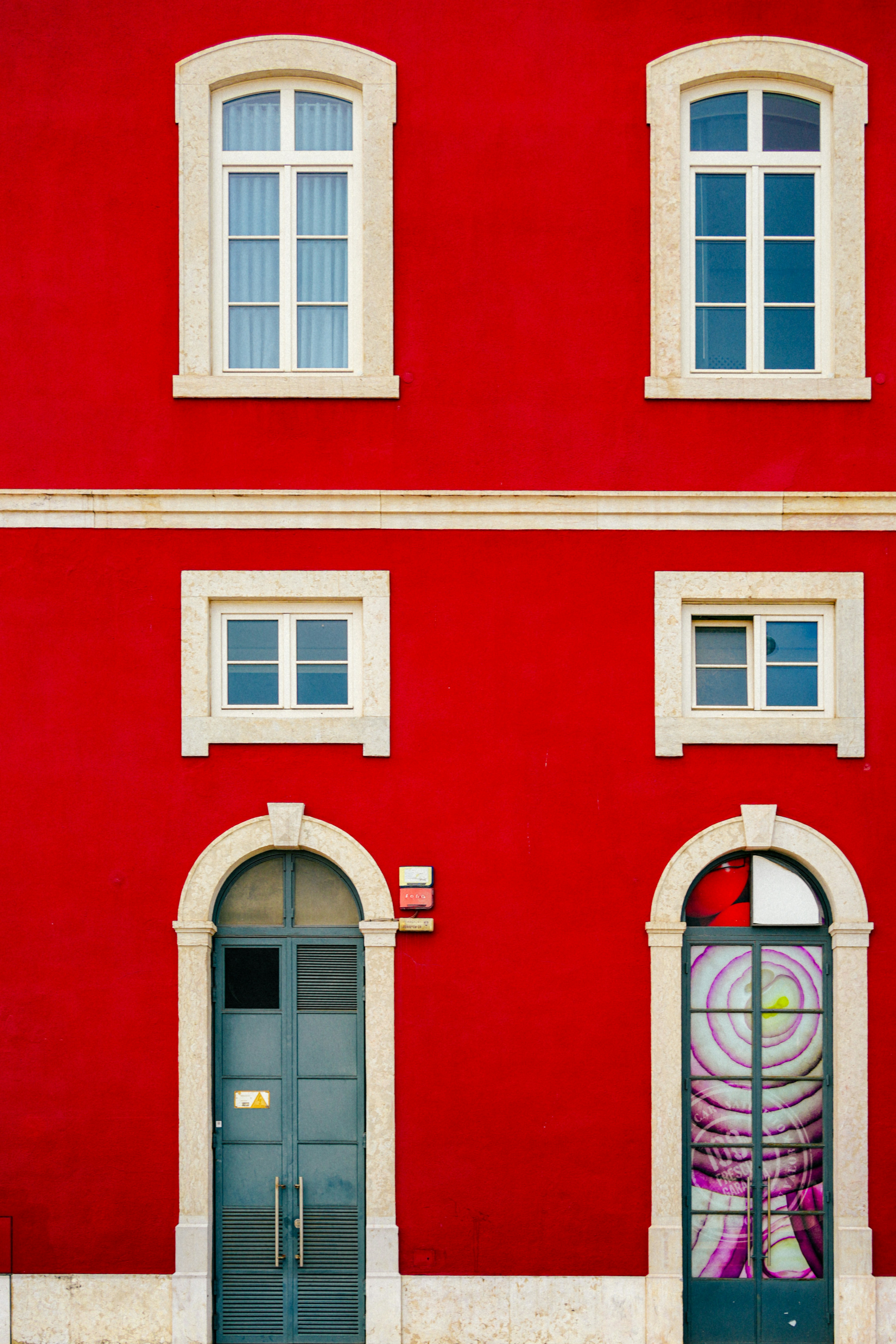 Red Facade with Arched Doors and Windows