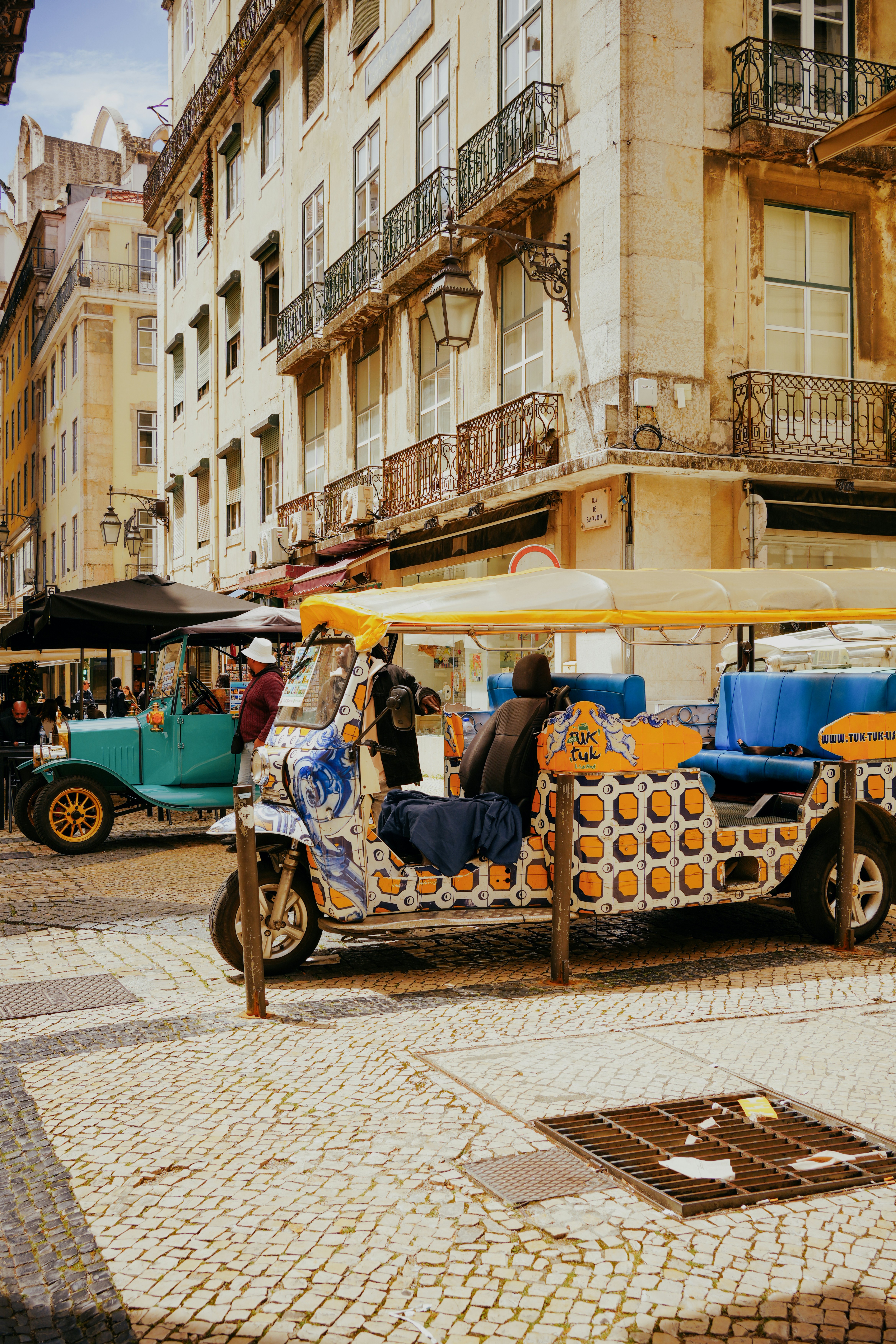 Sunlit Taxis and Cobblestones: A Lisbon Street Scene