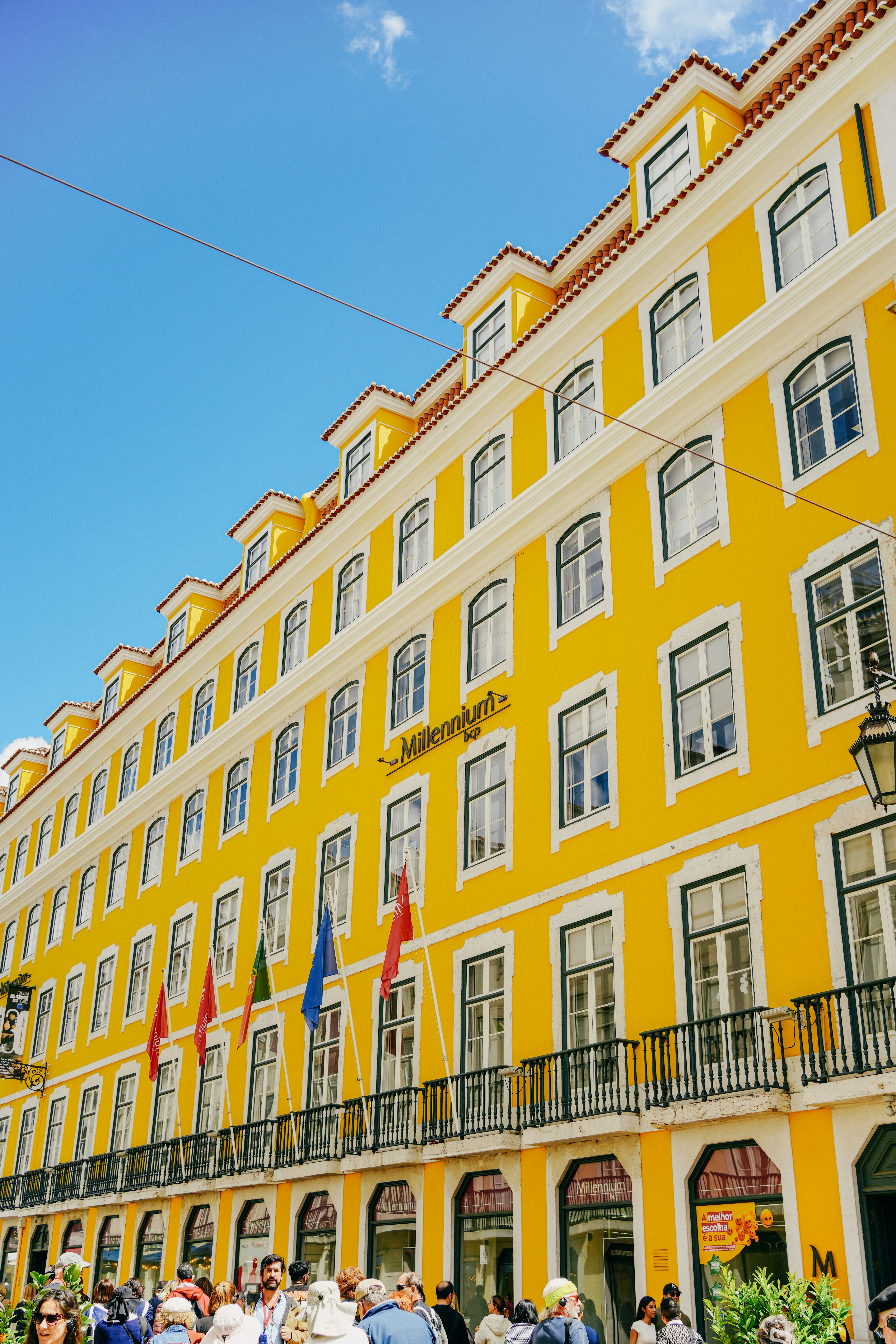 Sunlit Yellow Facade: The Millennium Hotel Lines and Bustling Street