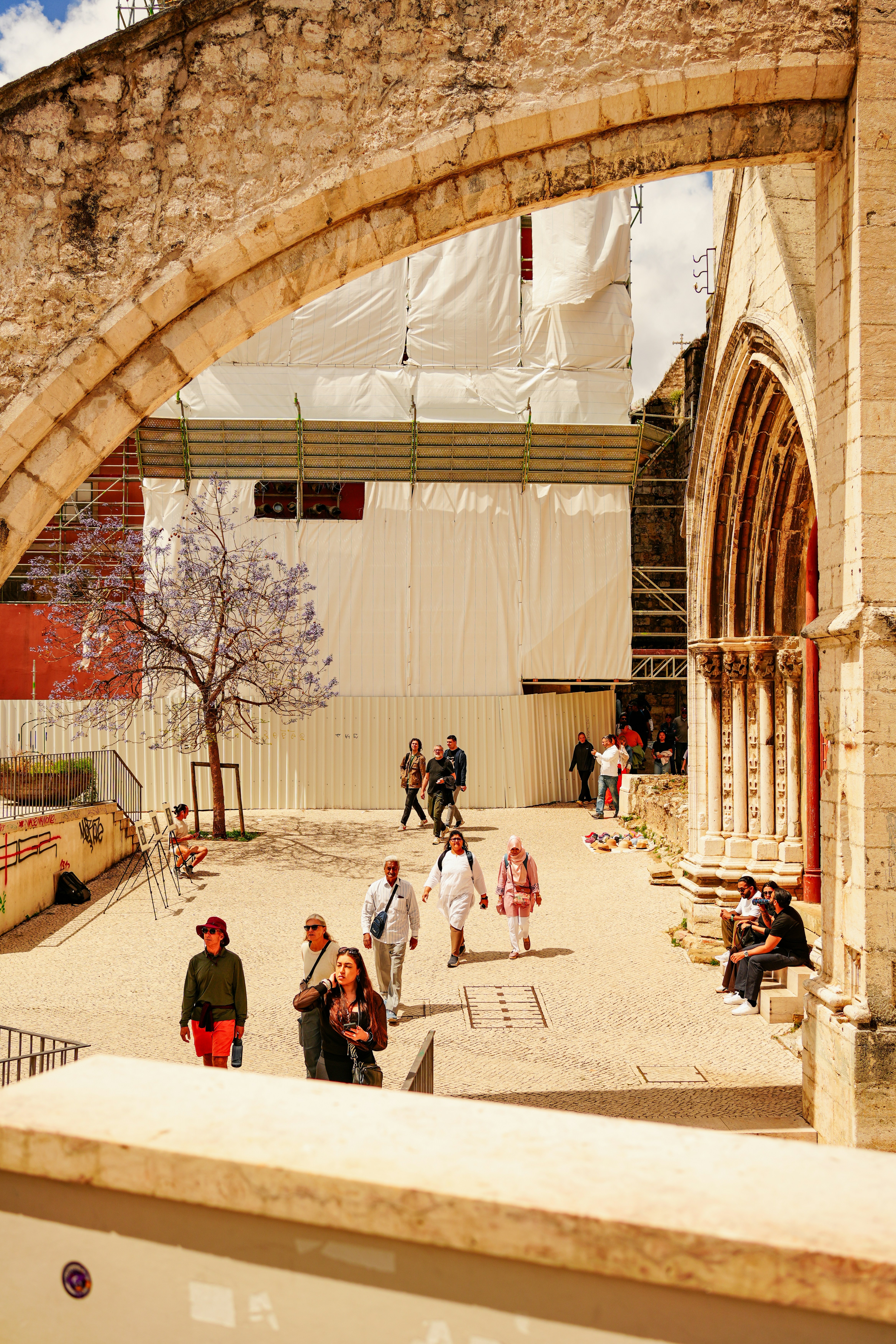 Sunny Courtyard Under the Arch: Tourists Gather in a Historic Portal