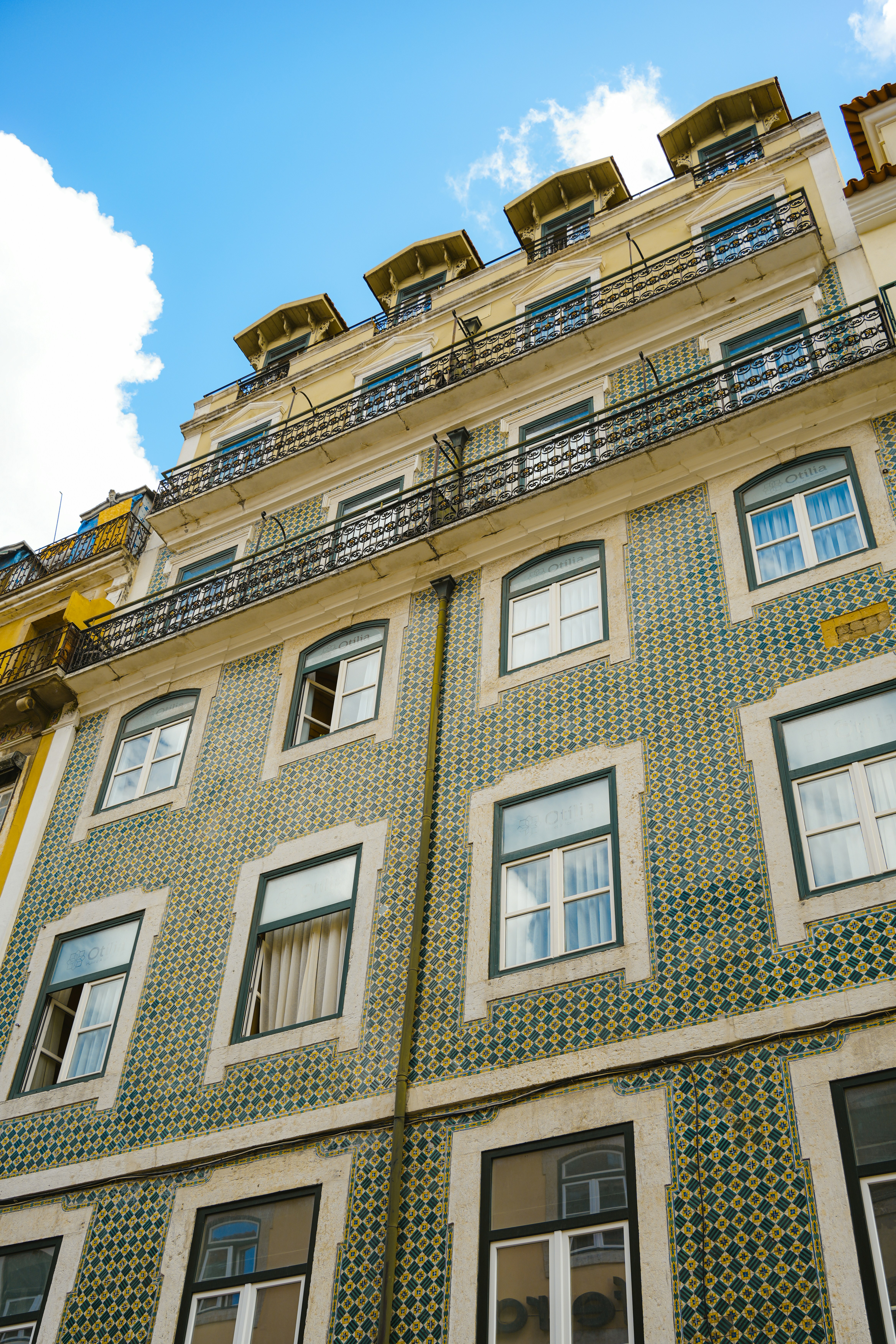 Facade with patterned tiles under a bright blue sky