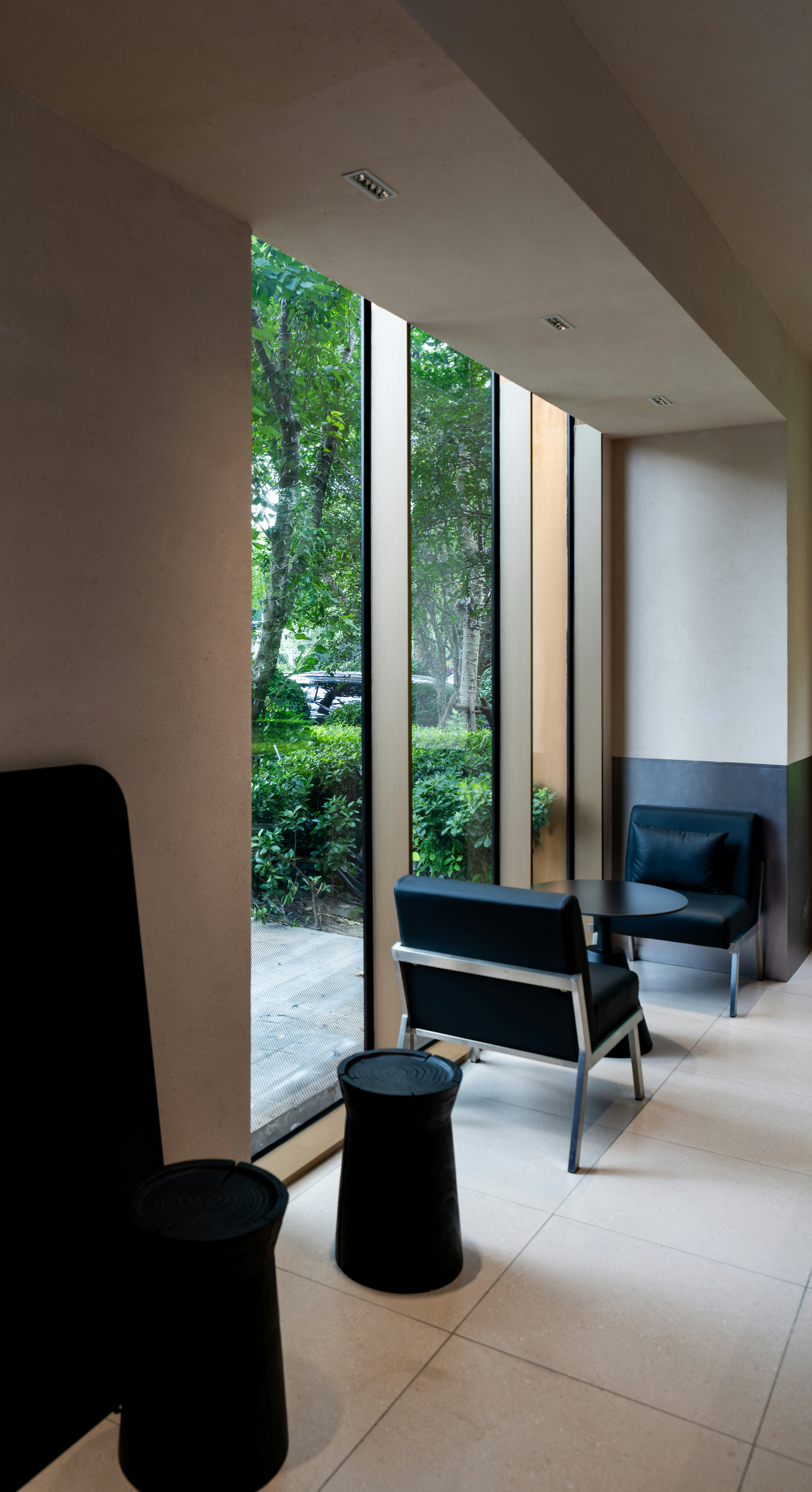 Quiet Corner by the Glass: Minimal Seating and Green Atrium