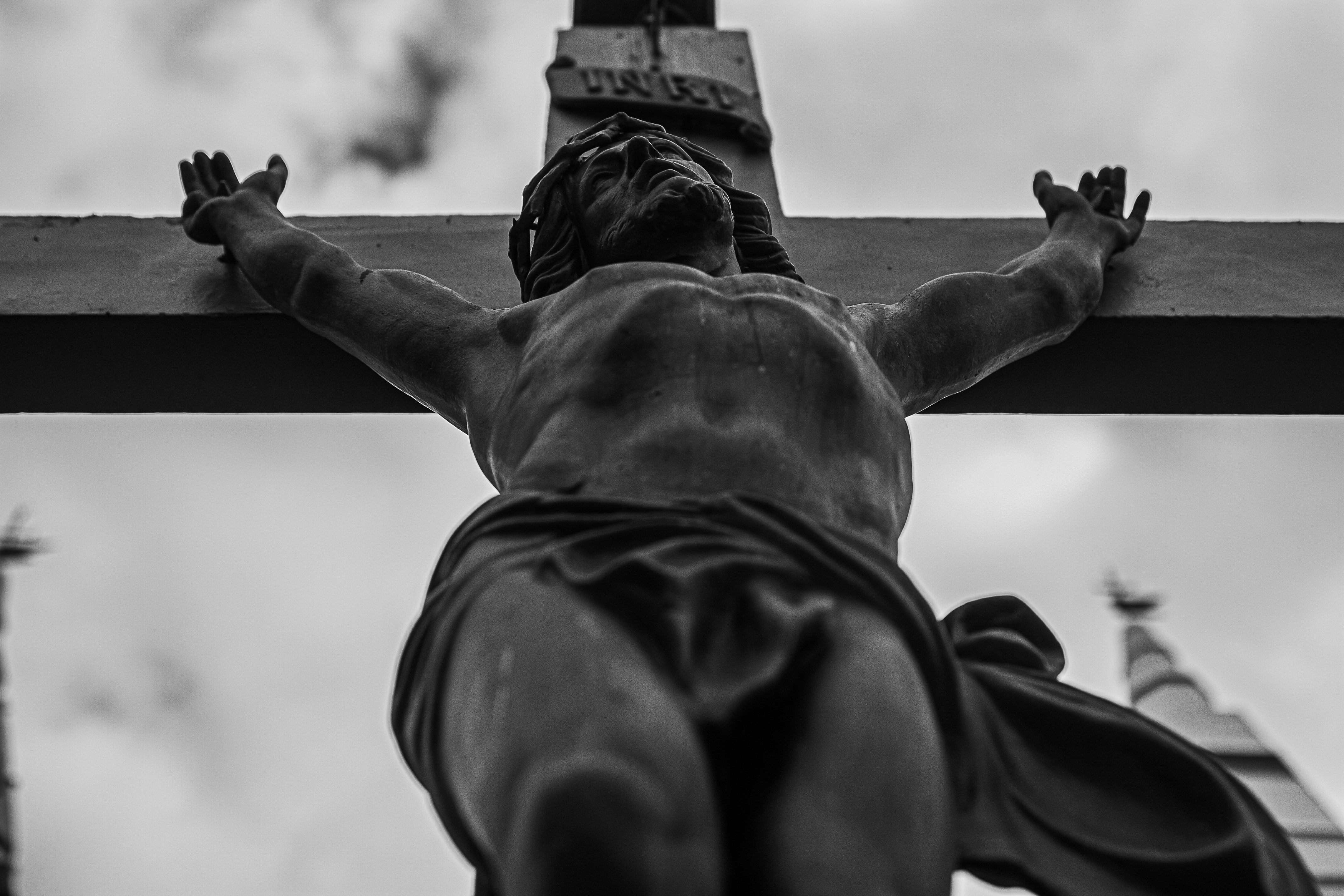 Cruciform Resolve: A Bronze Athlete Climbs Toward the Sky
