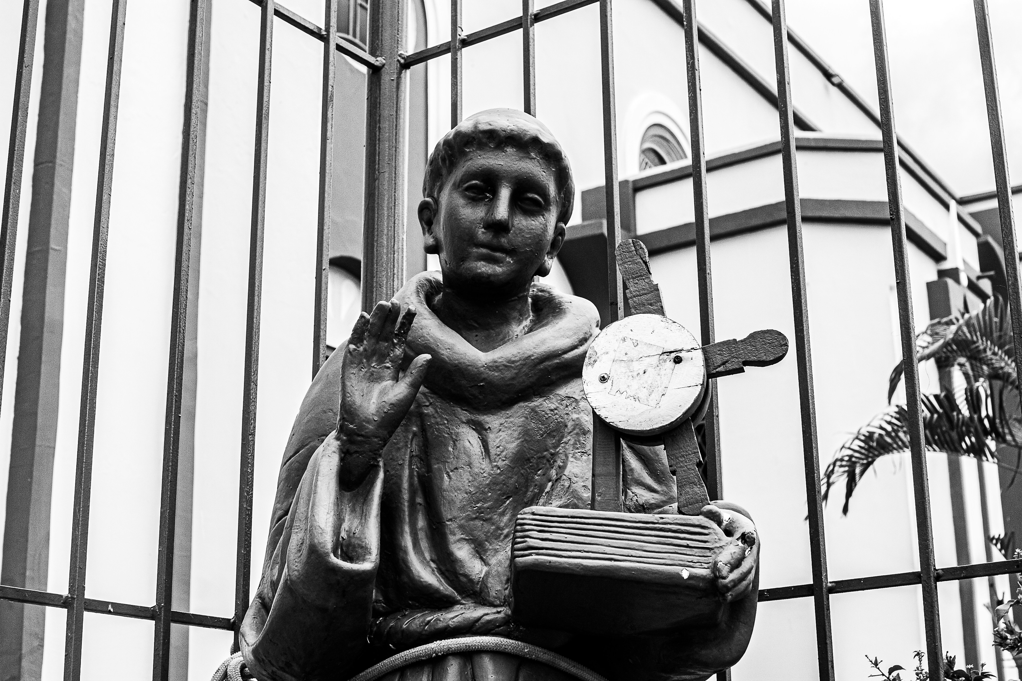 Statue in a Cage: A solemn monk with book and clock behind bars