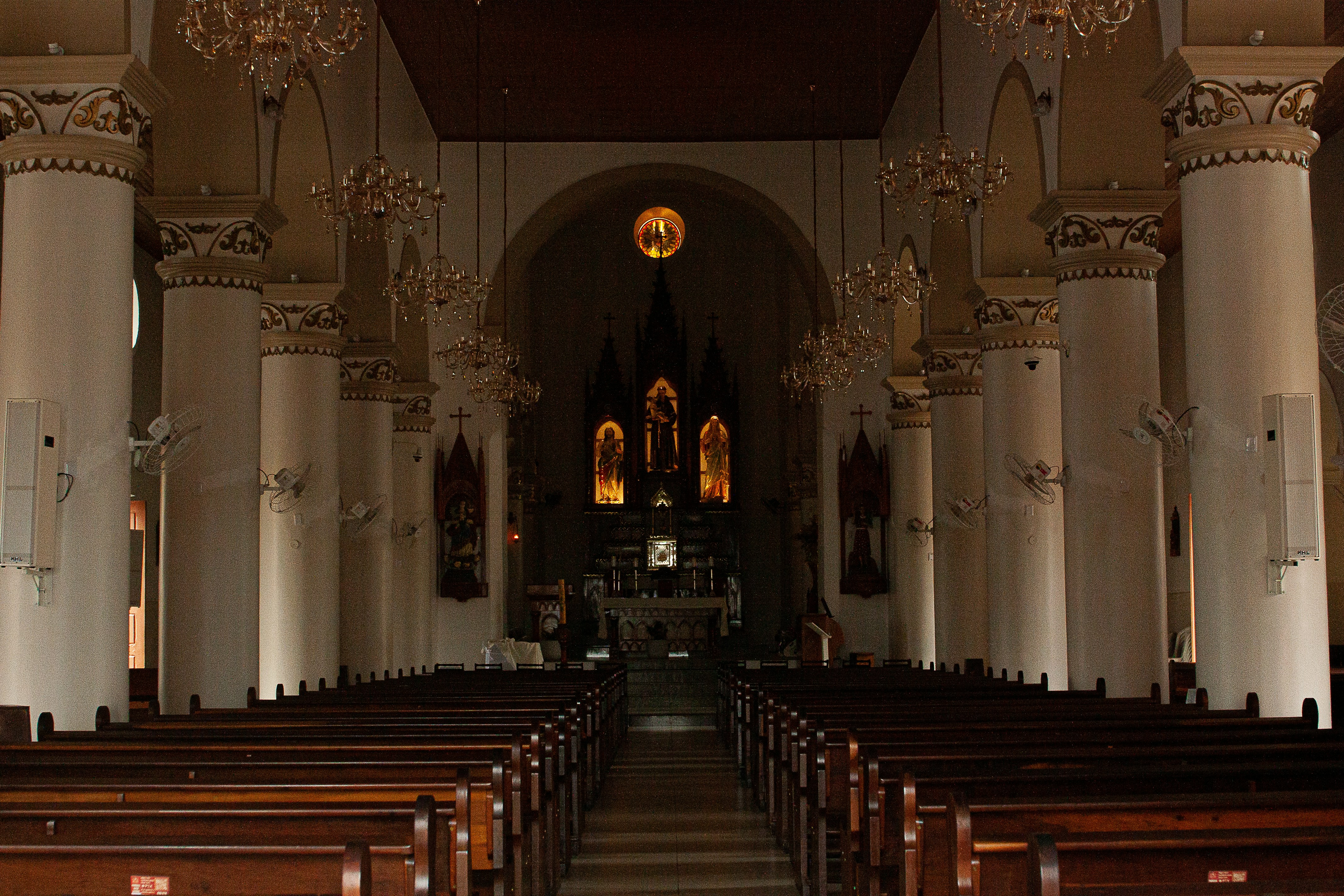 Cathedral Aisle Toward the Altarpiece: Symmetry Beneath the Chandeliers