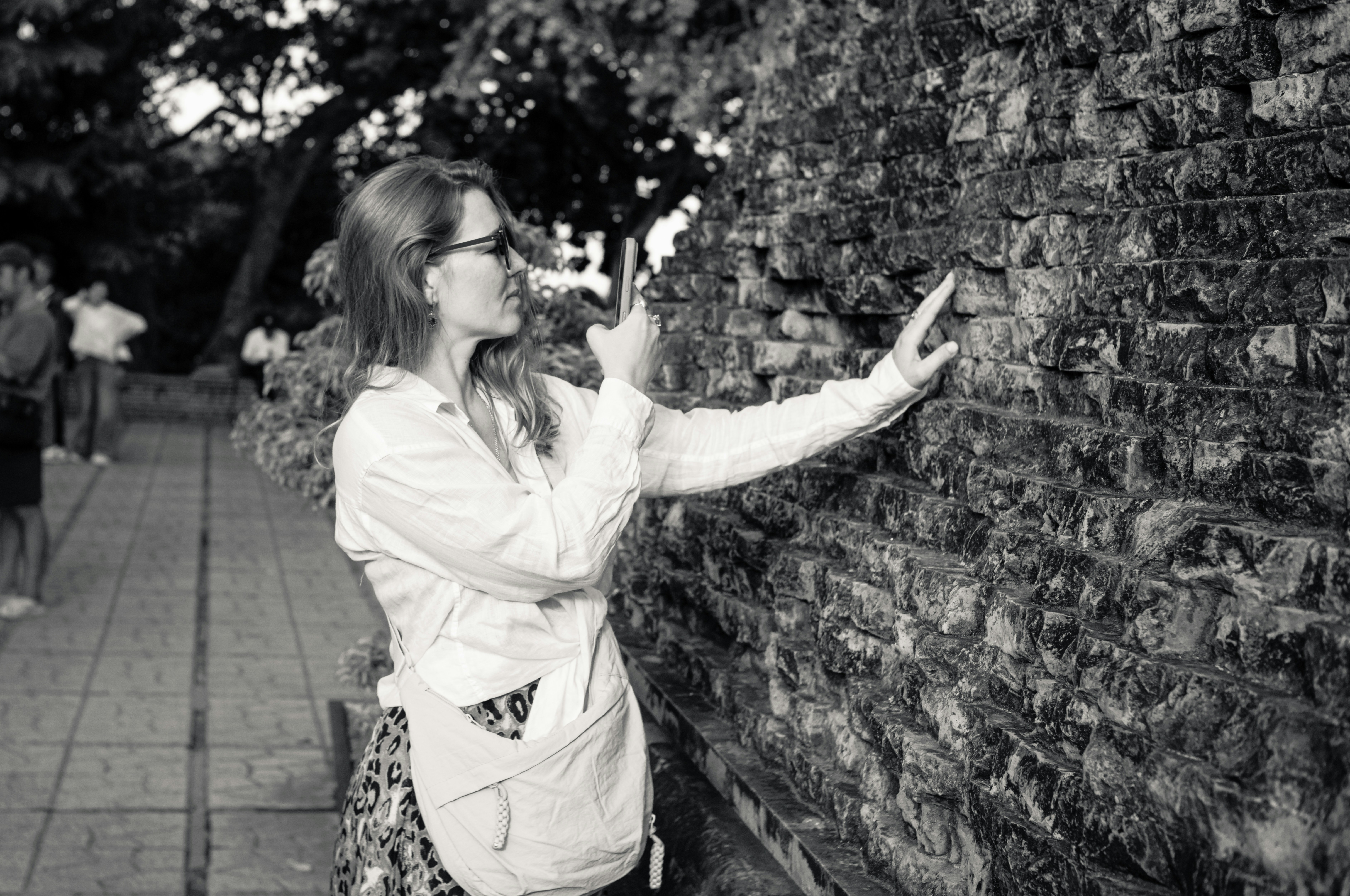 Touching the Wall: A Quiet Portrait by the Riverside Path