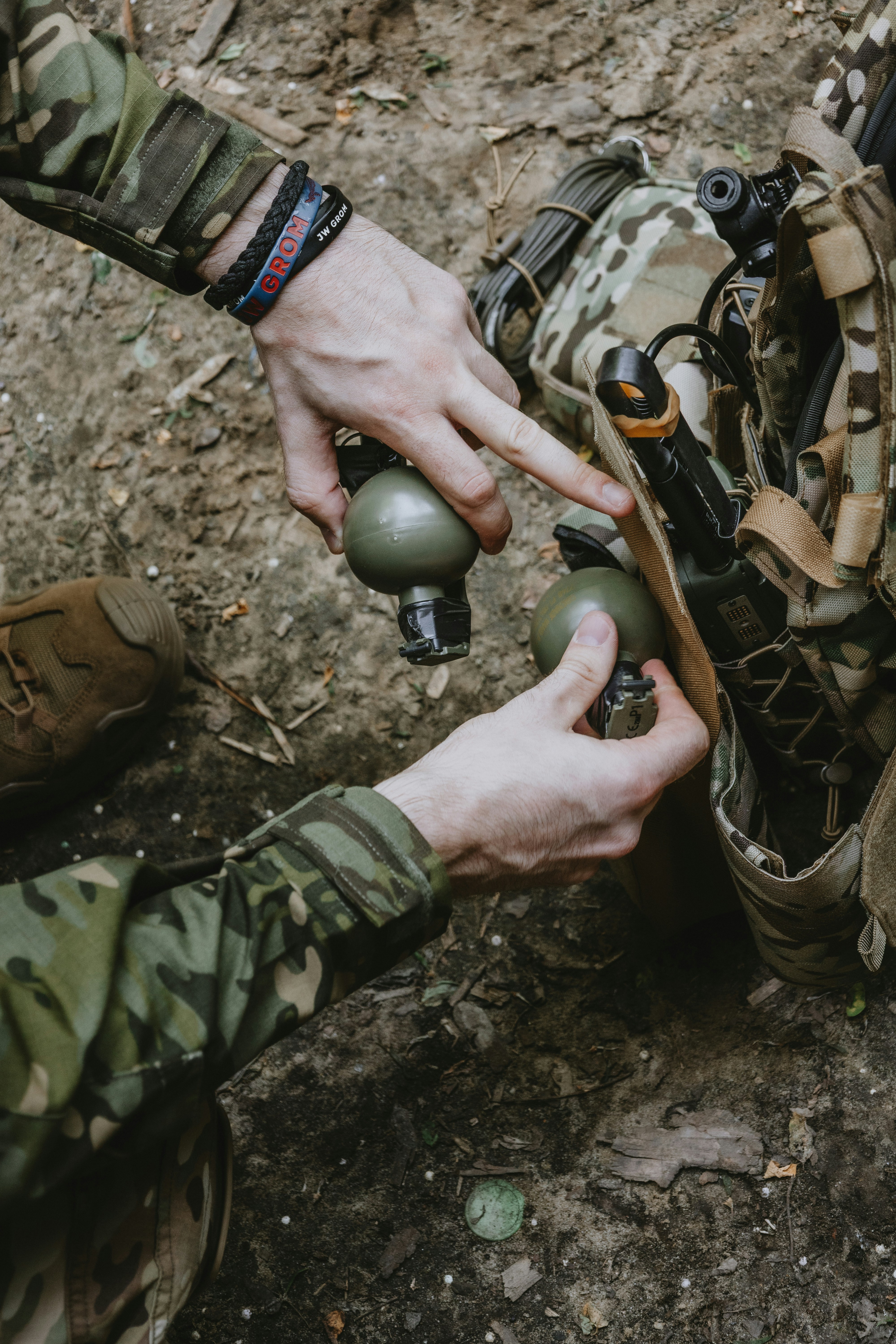 Preparing a grenade during an airsoft match in a woodland environment.