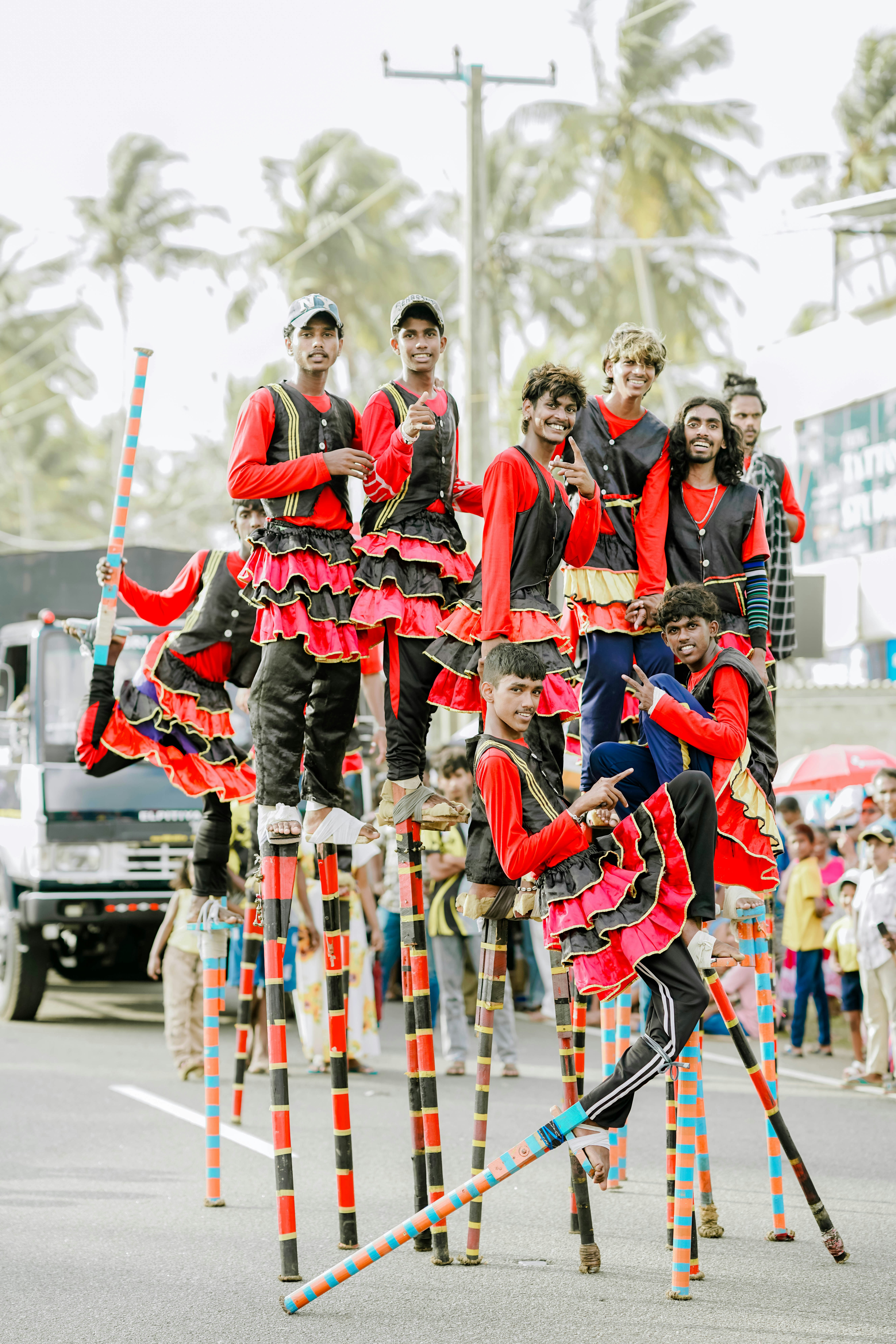 Colorful Stilt Performers Parade: A Line of Balancing Dancers in Red and Black