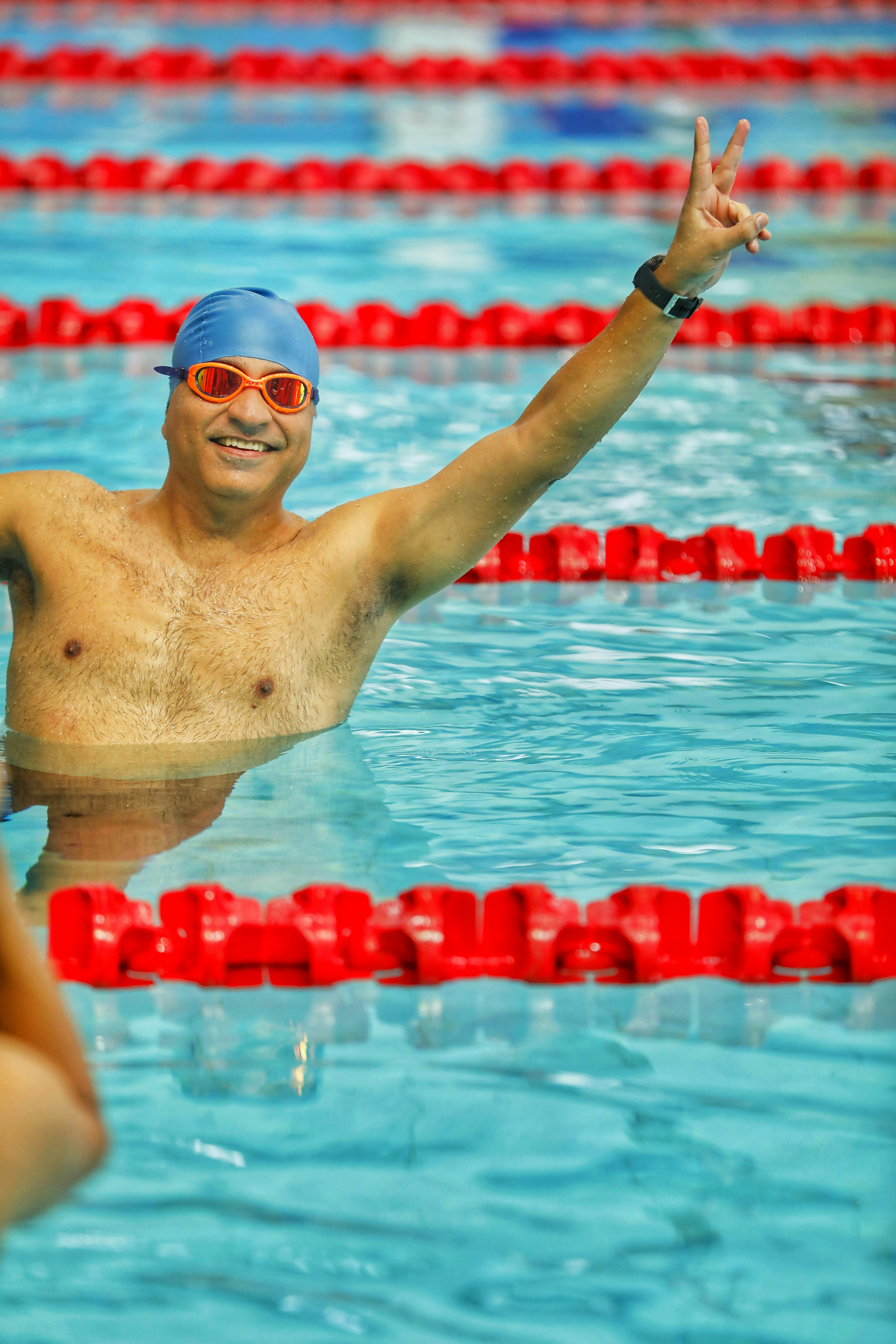 Victory Wave: Swimmer Raising a Cheerful Canopy of Triumph