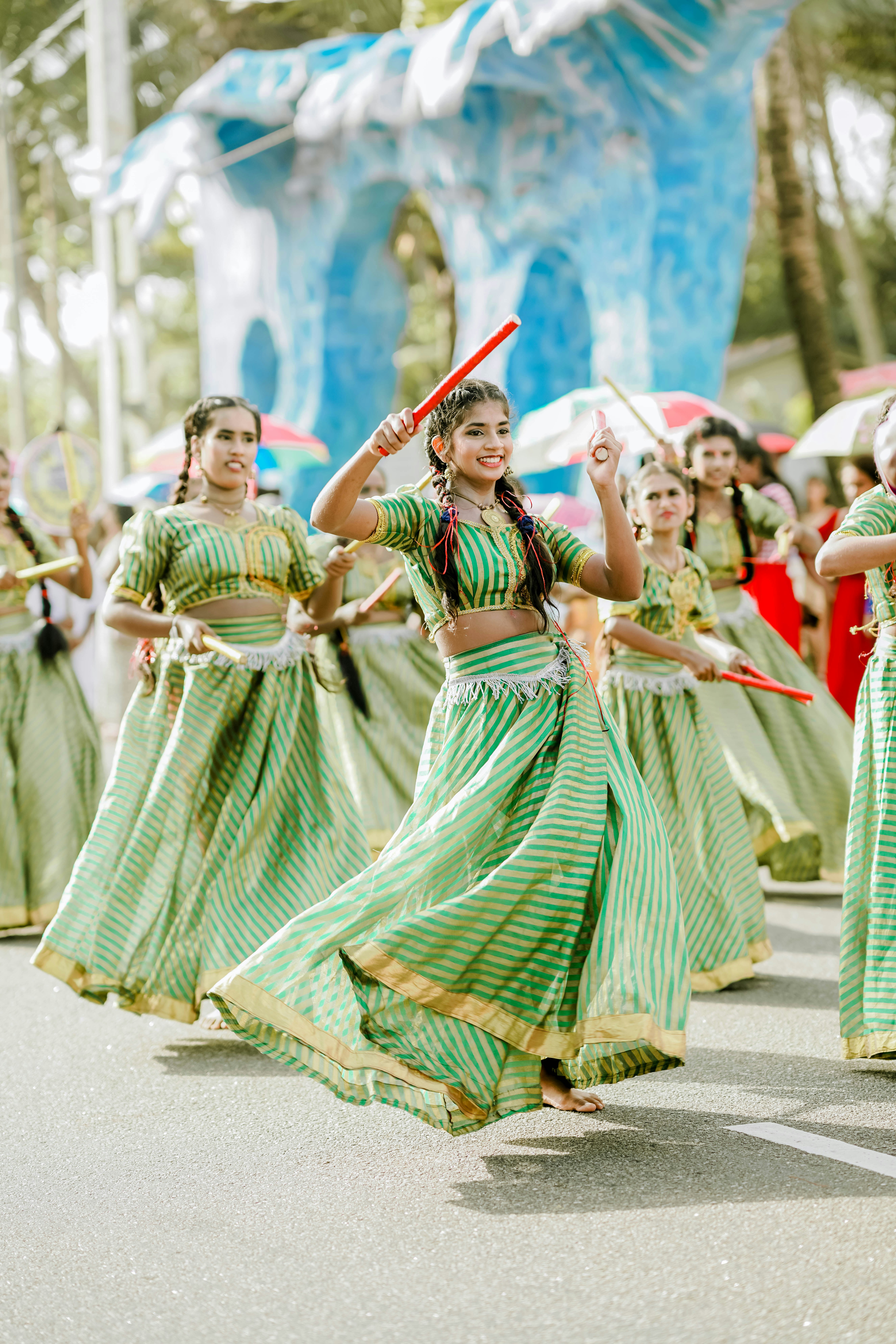 Green Swirl: Dancers in Synchrony Under a Cool Blue Arch