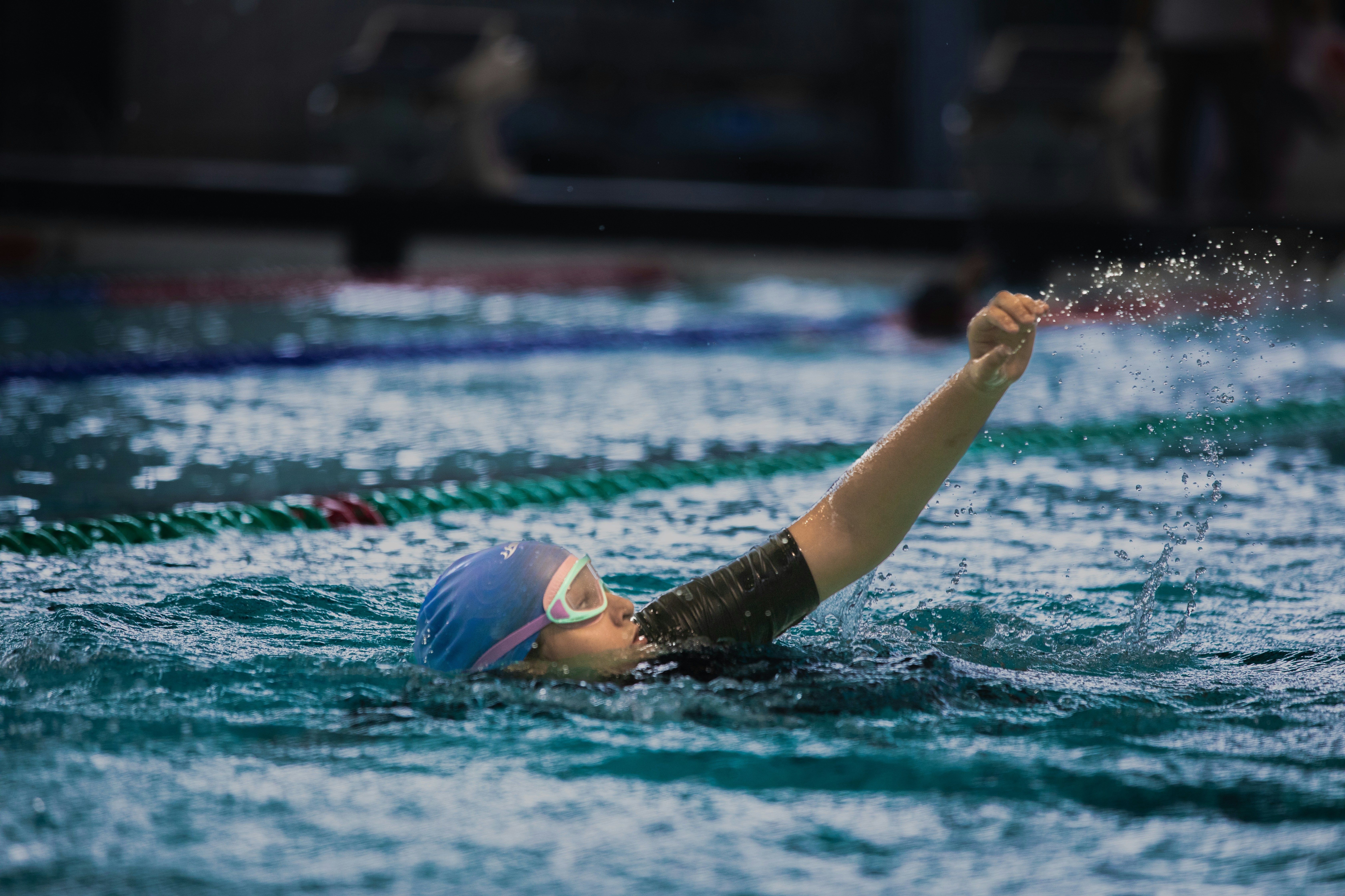 The Hydrodynamic Reach: A Swimmer's Arm Slice Through Turquoise Ripples