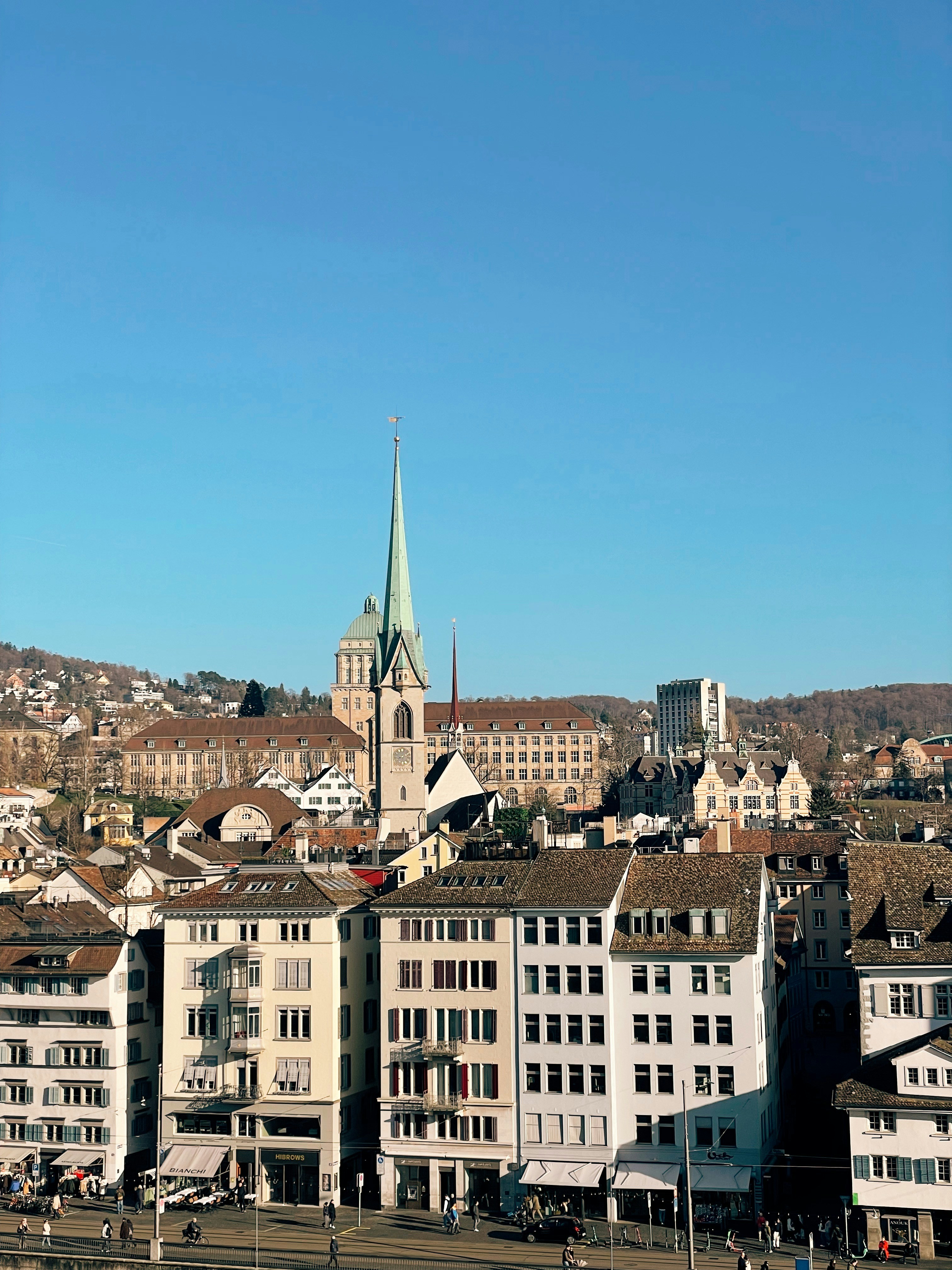 Staircase of rooftops and a church spire over a Swiss town