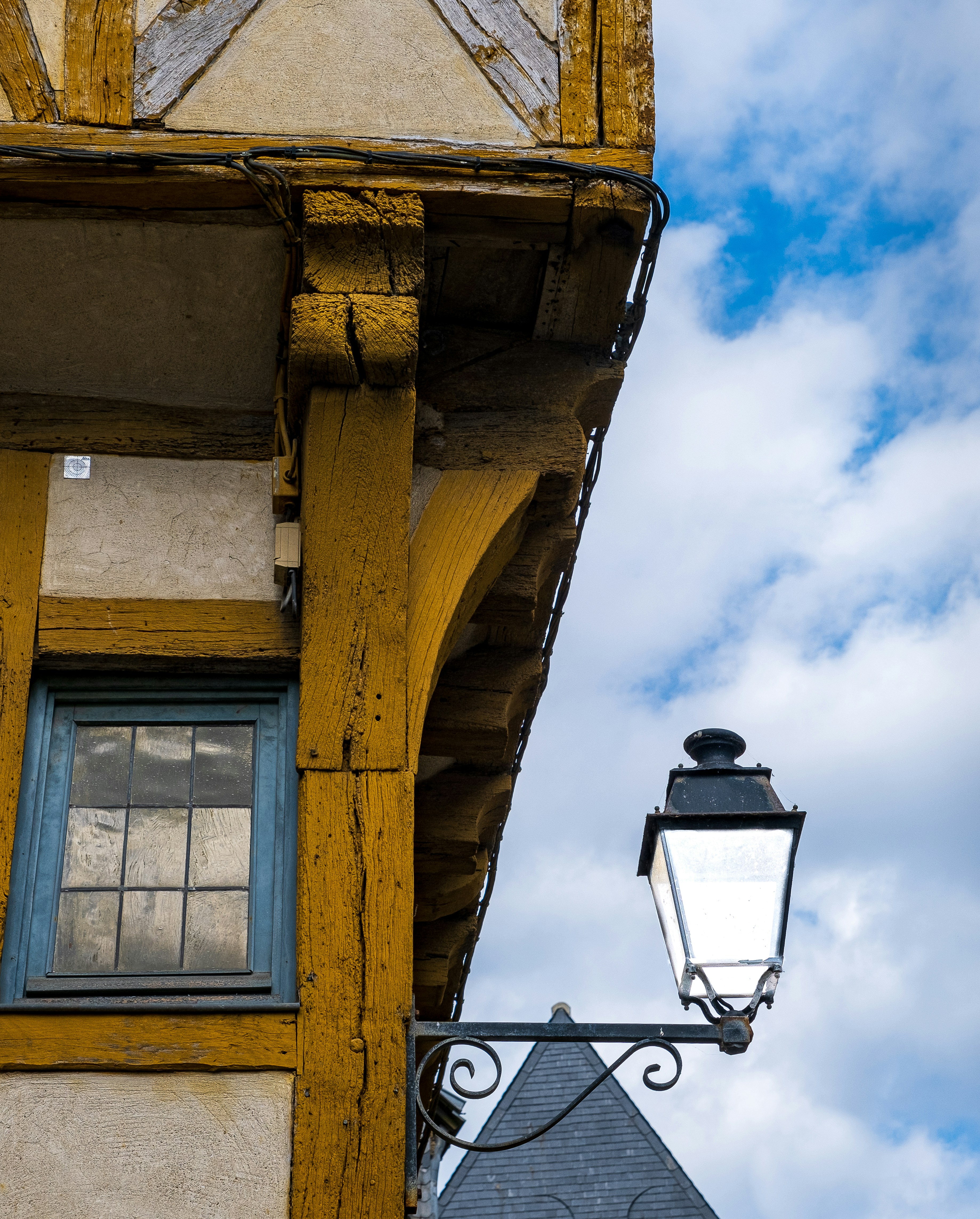 Yellow Timbered Corner Under a Blue Sky With Lantern