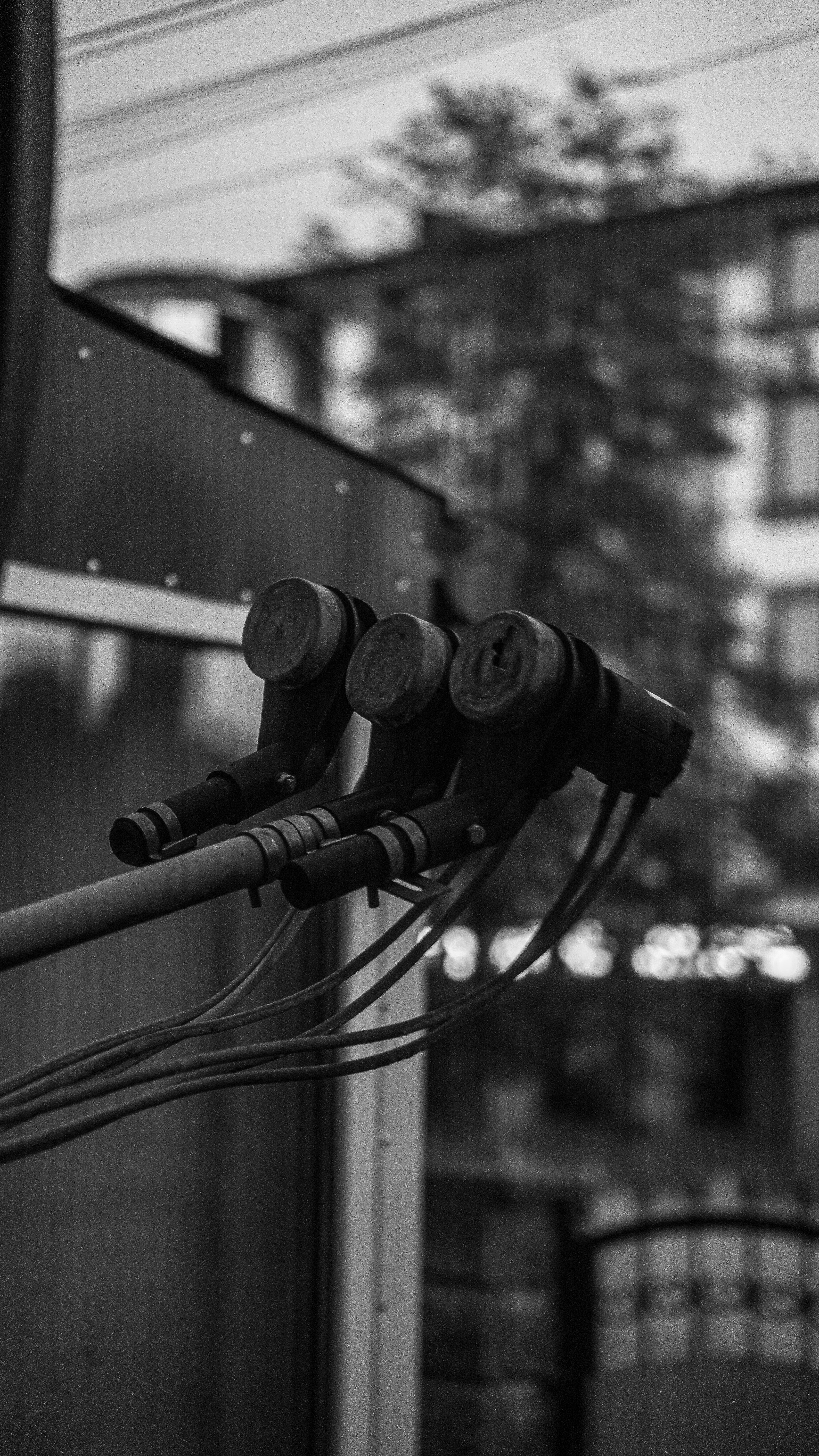 Cabled Monochrome: A Cluster of Outdoor Rigging against a Blurred Urban Backdrop