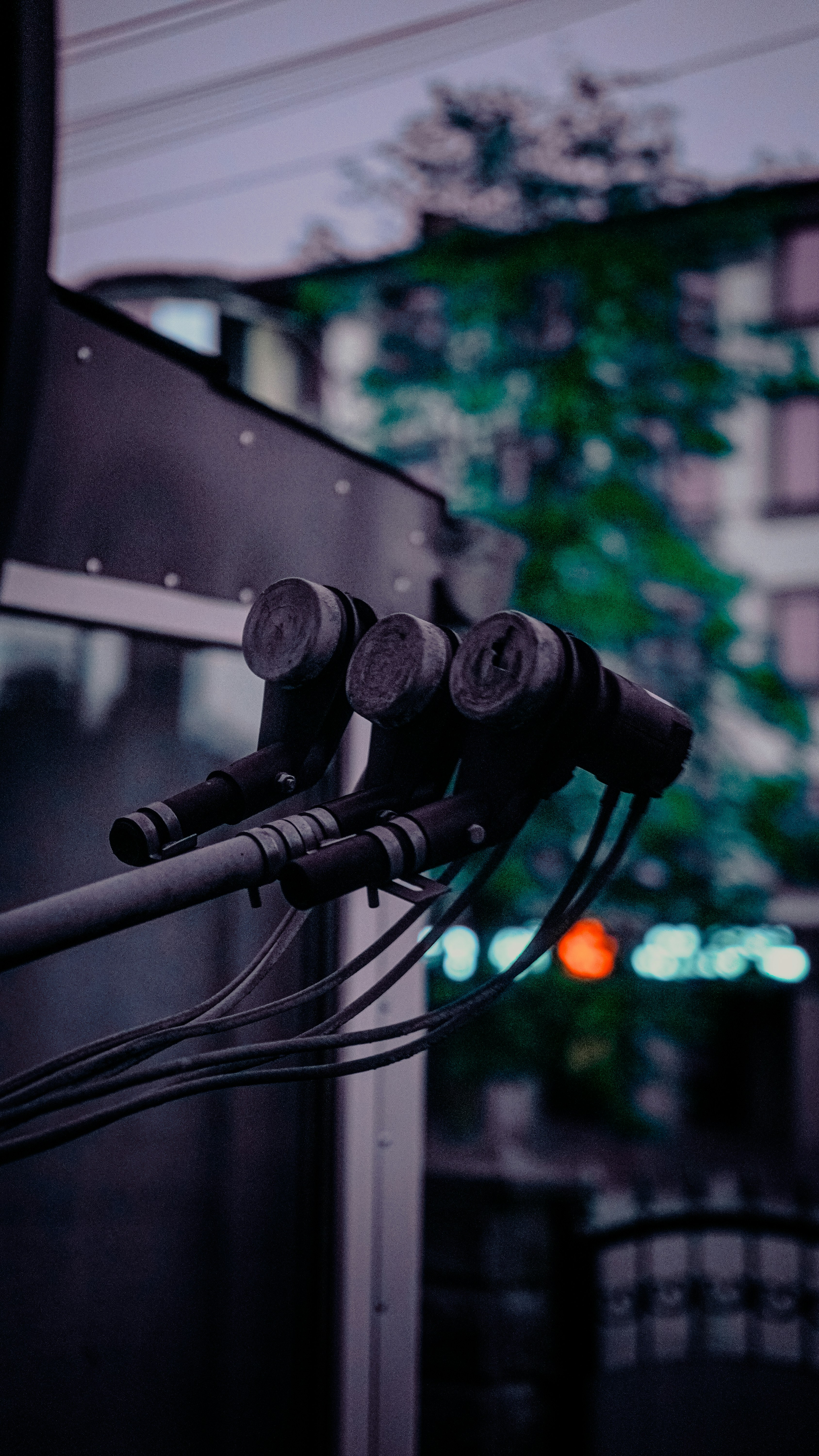 Cables at Dusk: Weathered Connectors against a Neon-Bokeh Street