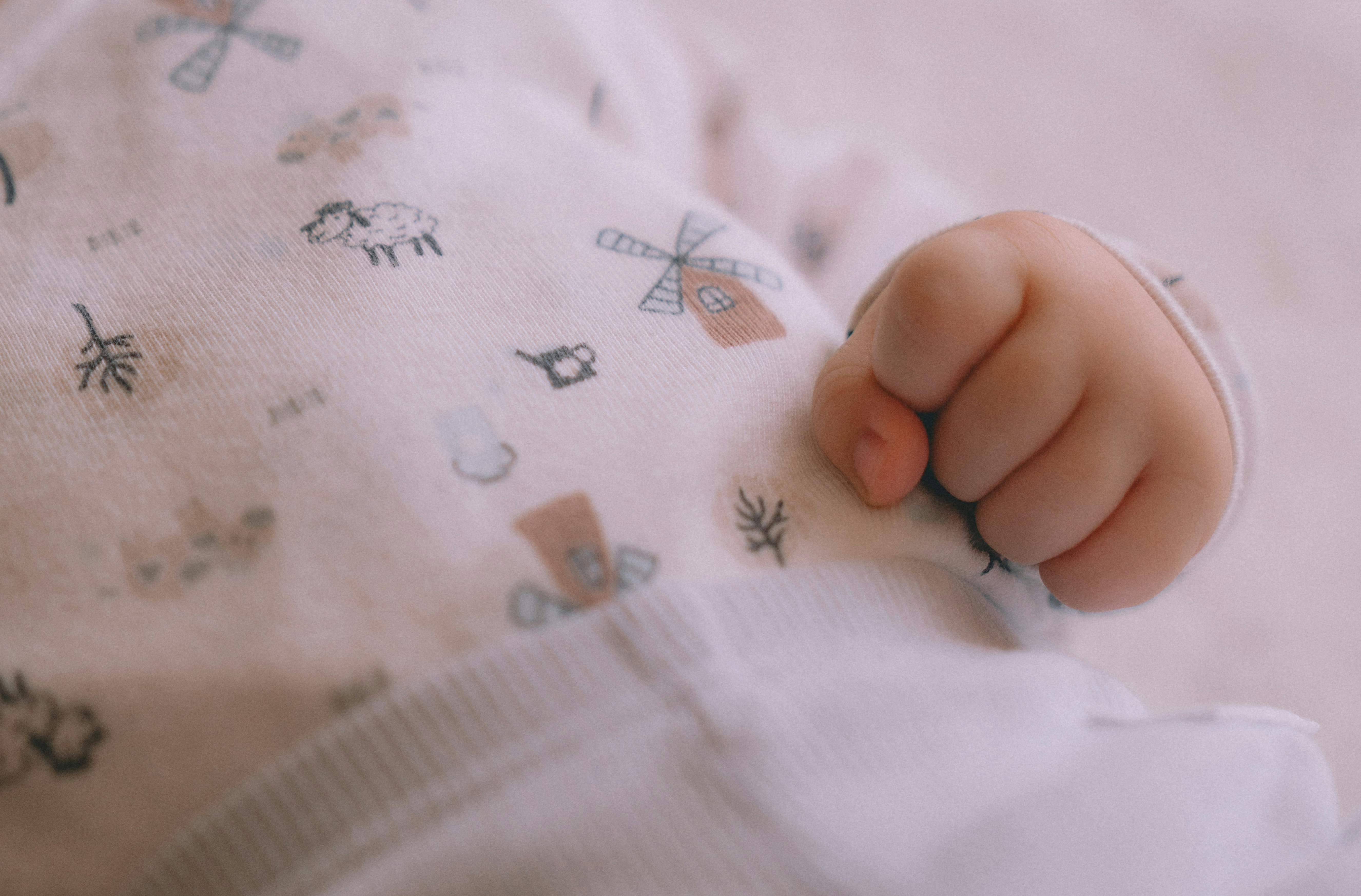Gentle Grasp: A Baby's Quiet Moment in Soft Fabric