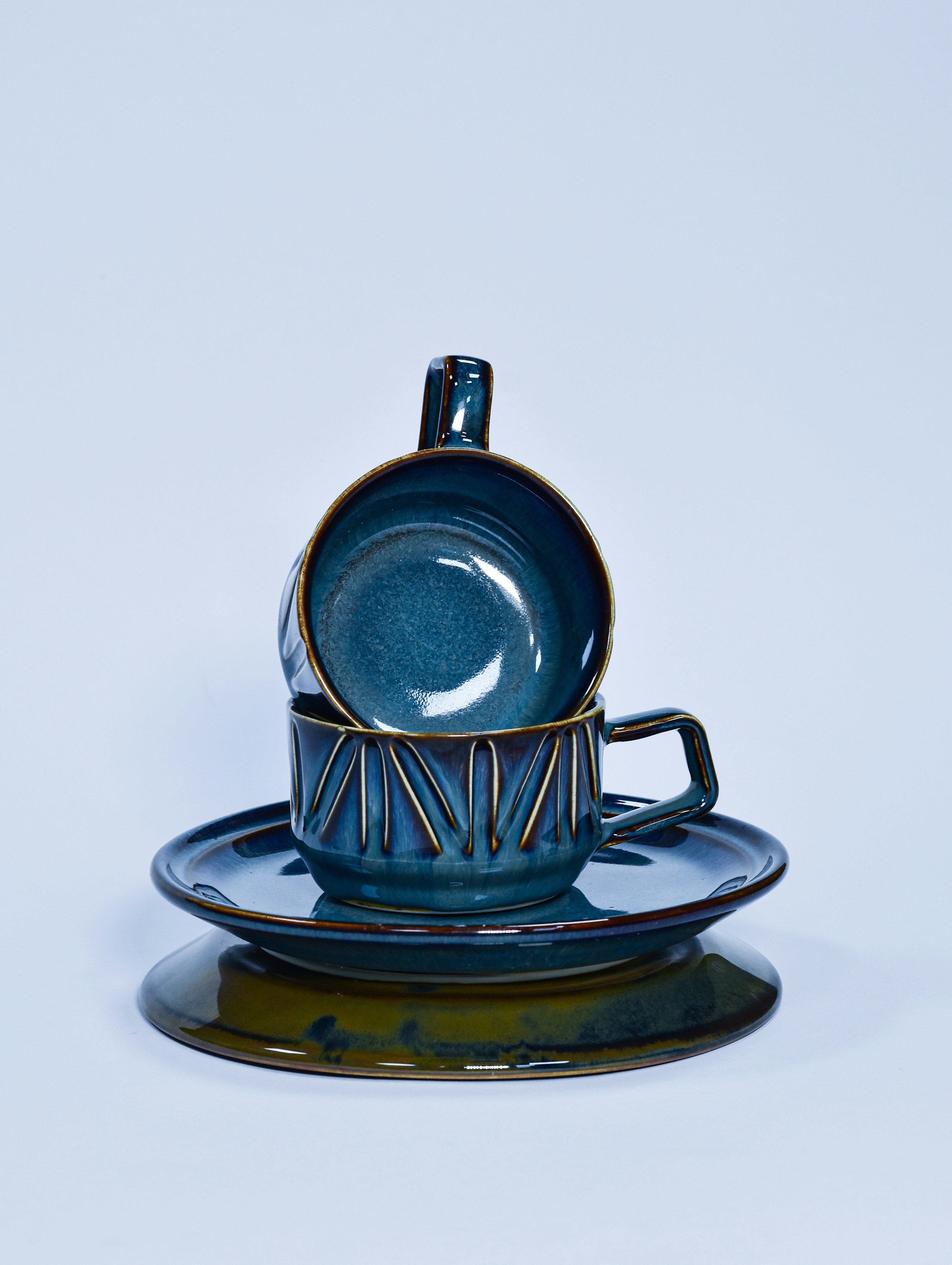 Ceramic Cupstack: A Balanced Still Life with Teal Glaze and Textured Rim