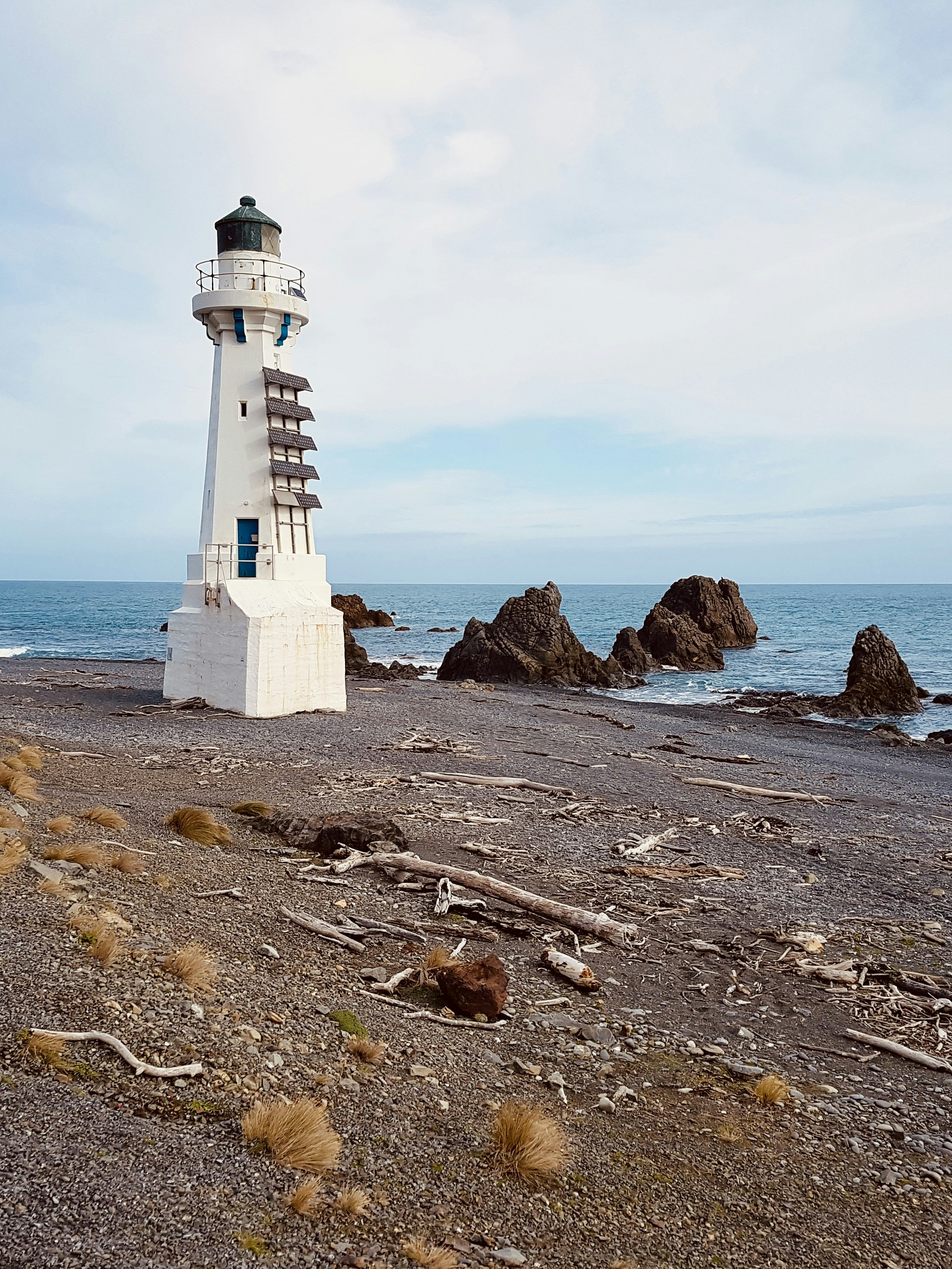 White Lighthouse Quietly Guarding a Rocky Shore