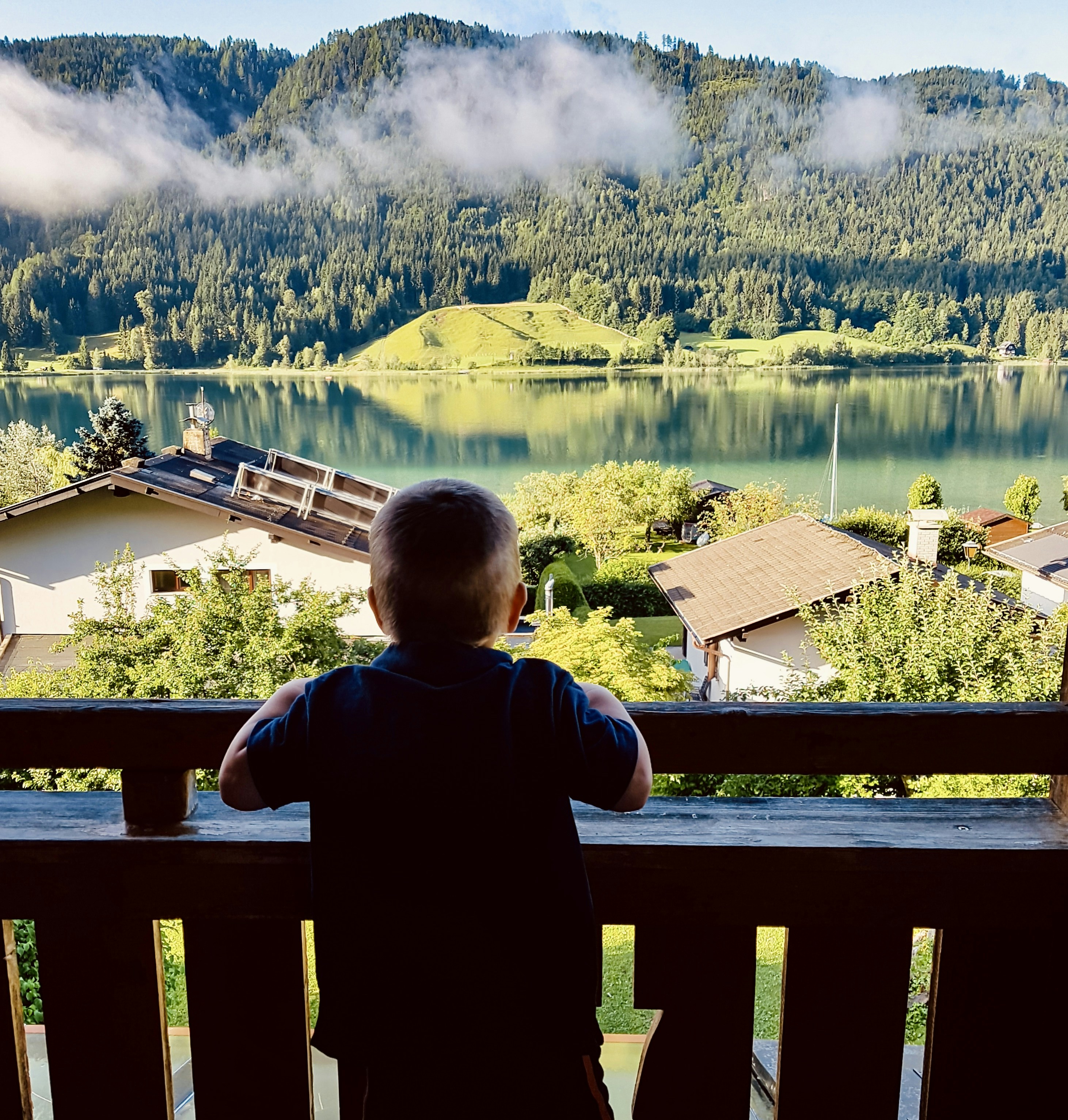 Child on the Balcony Overlooking a Lake Valley