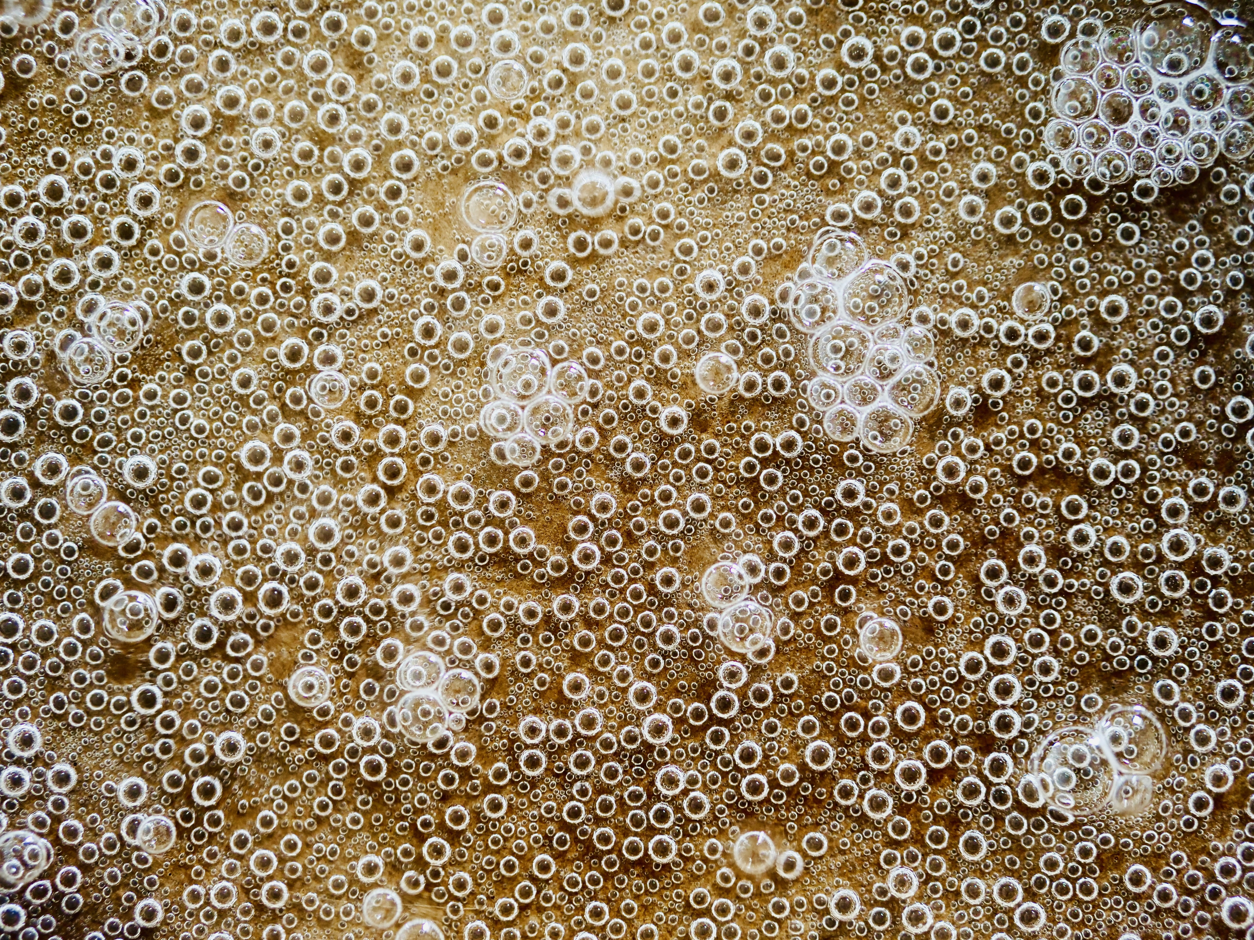 Bubble Mosaic: Close-Up of Foamy Orbs on a Golden Surface