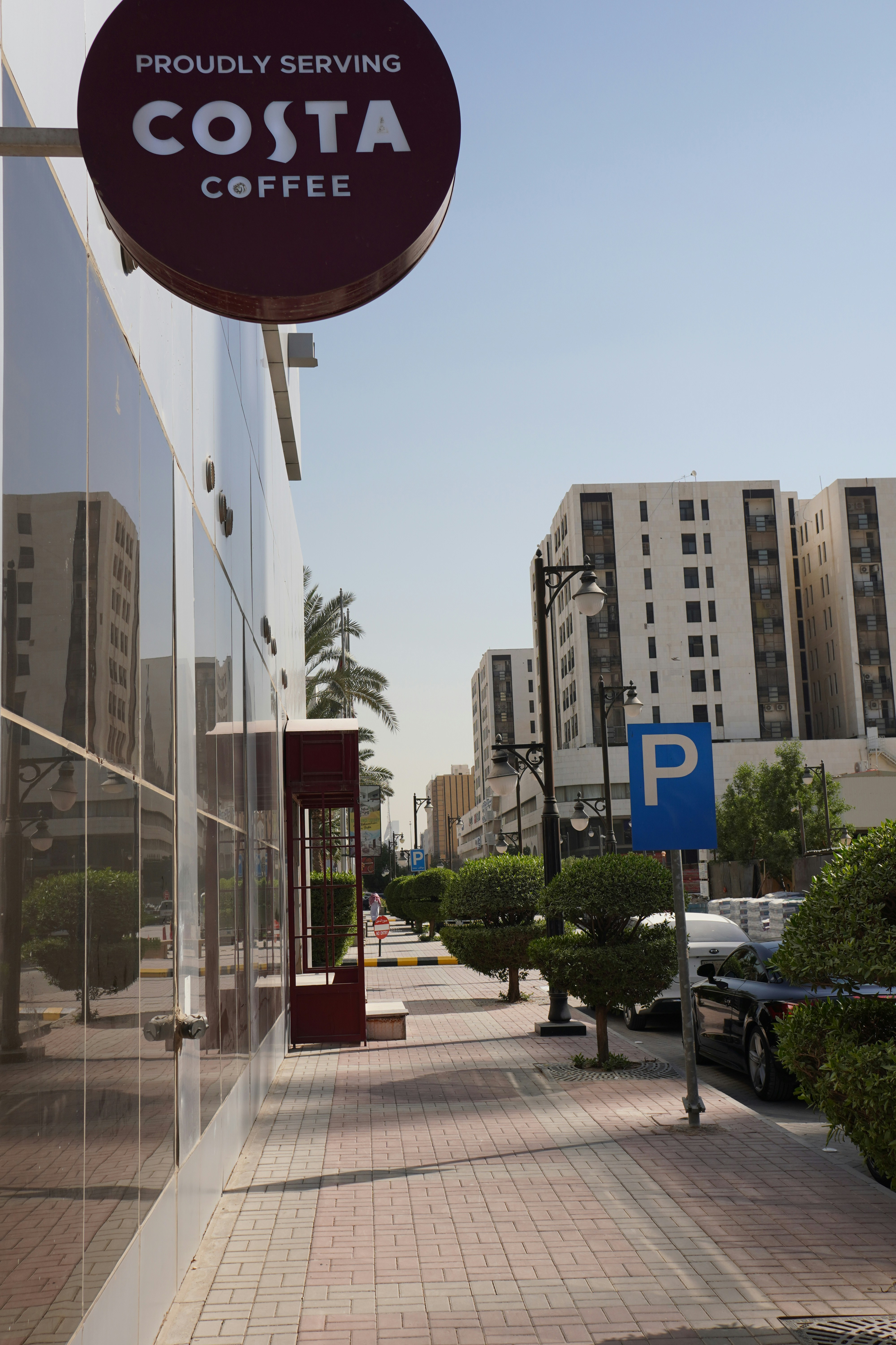 Costa Coffee Signoverlooking a sunlit city sidewalk