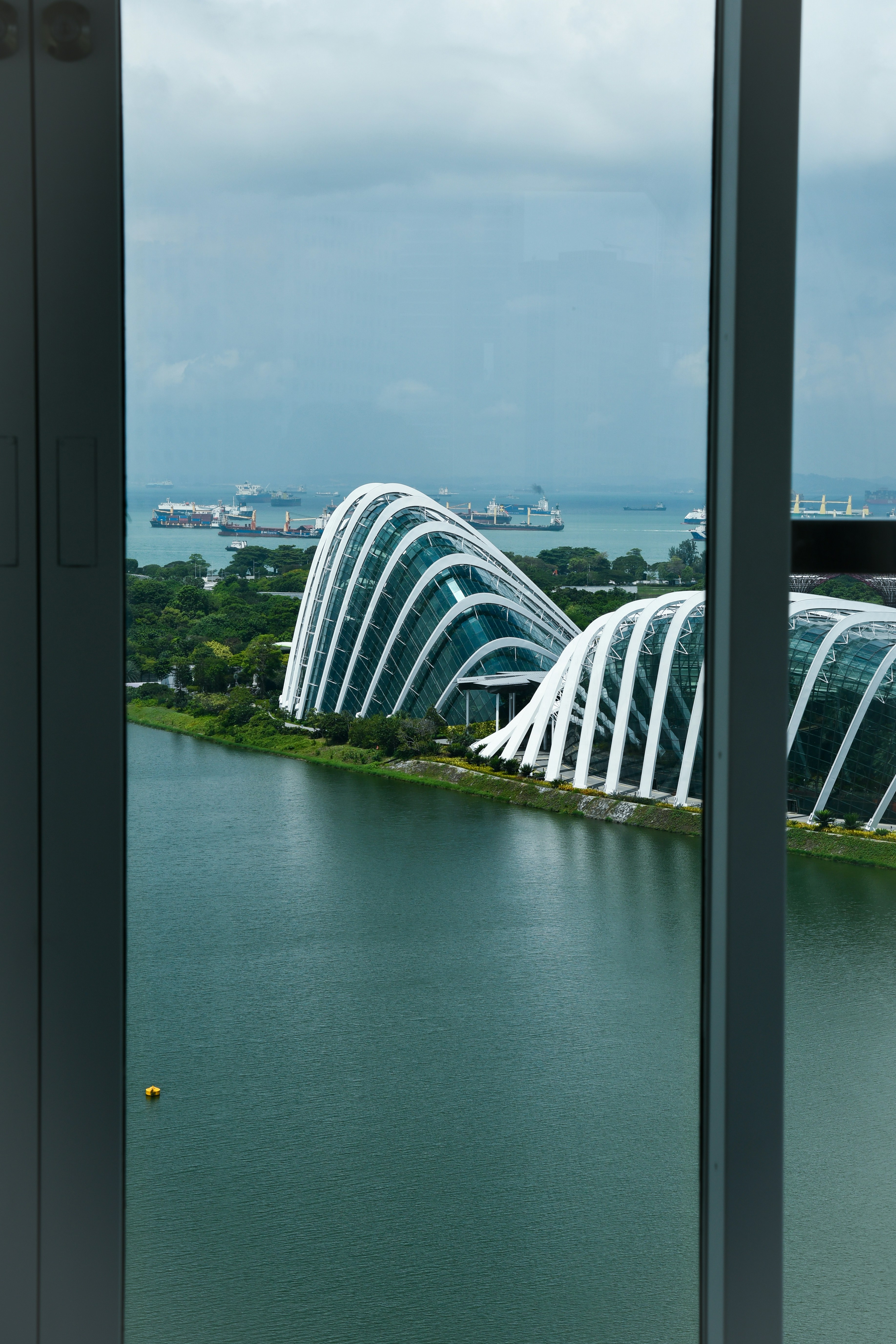 Curved glass sanctuaries along the marina framed by a tall window