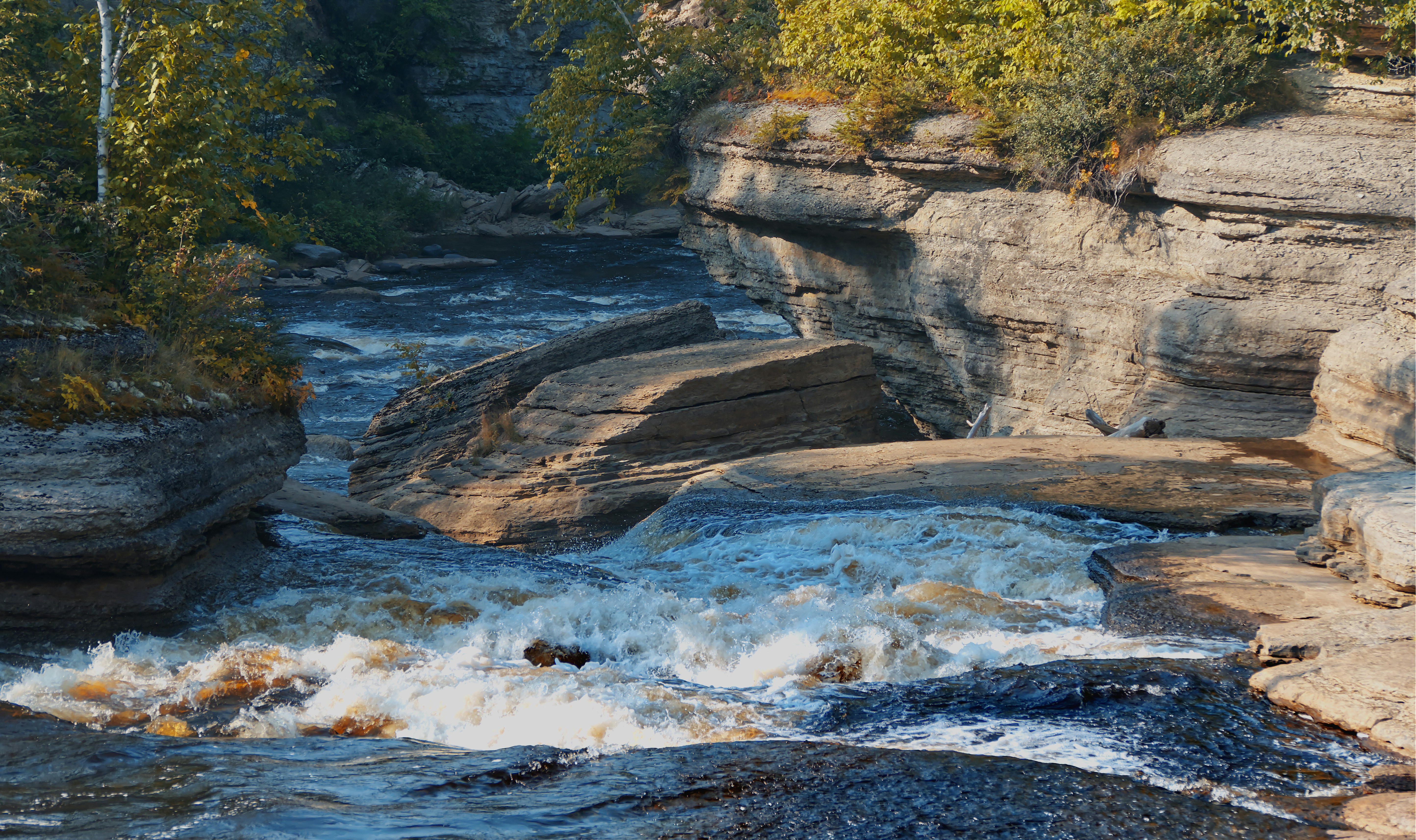 River carved stairs: cascading blue-green water over layered rock