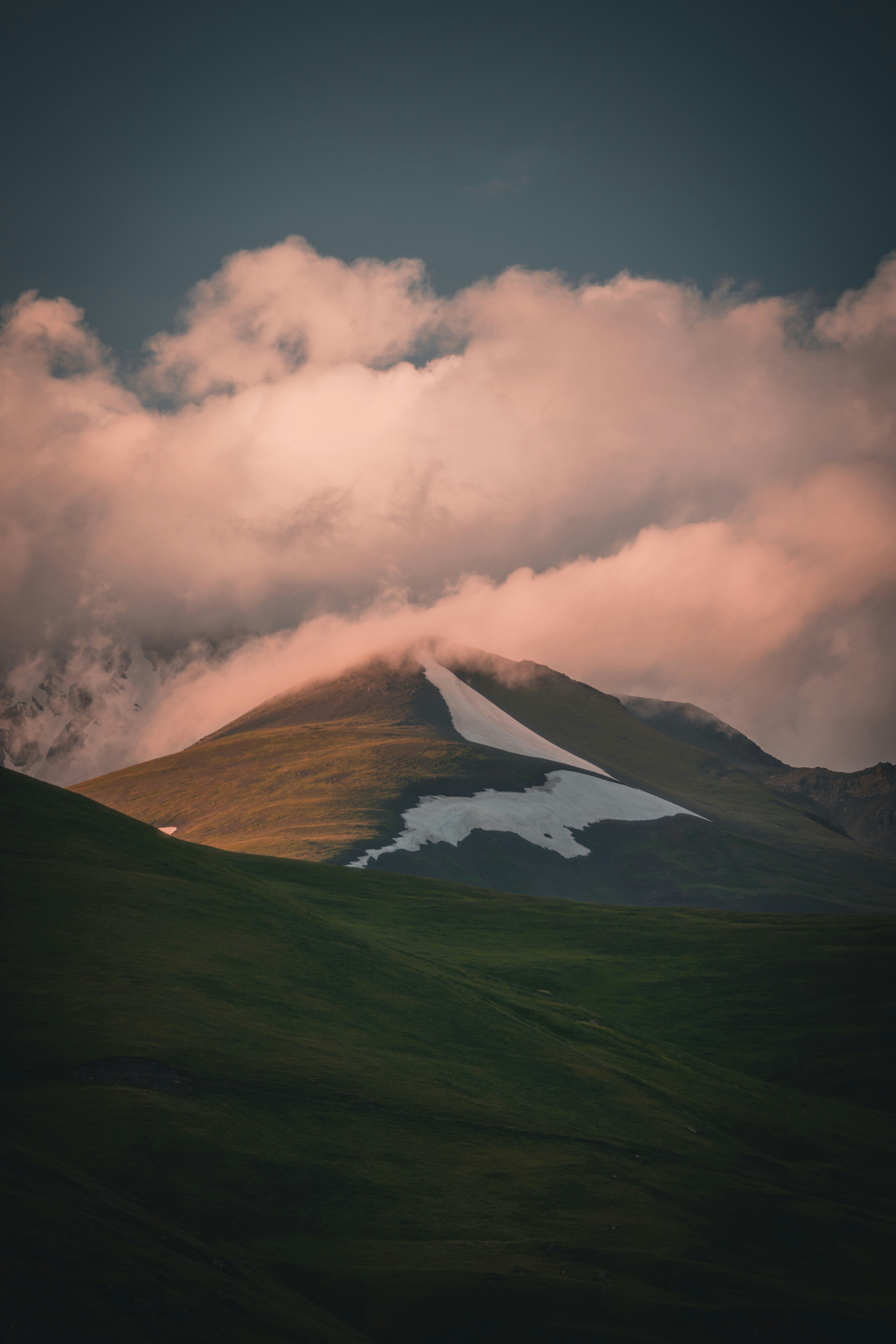 Peak in Sunset Haze over Snow-Patched Ridge