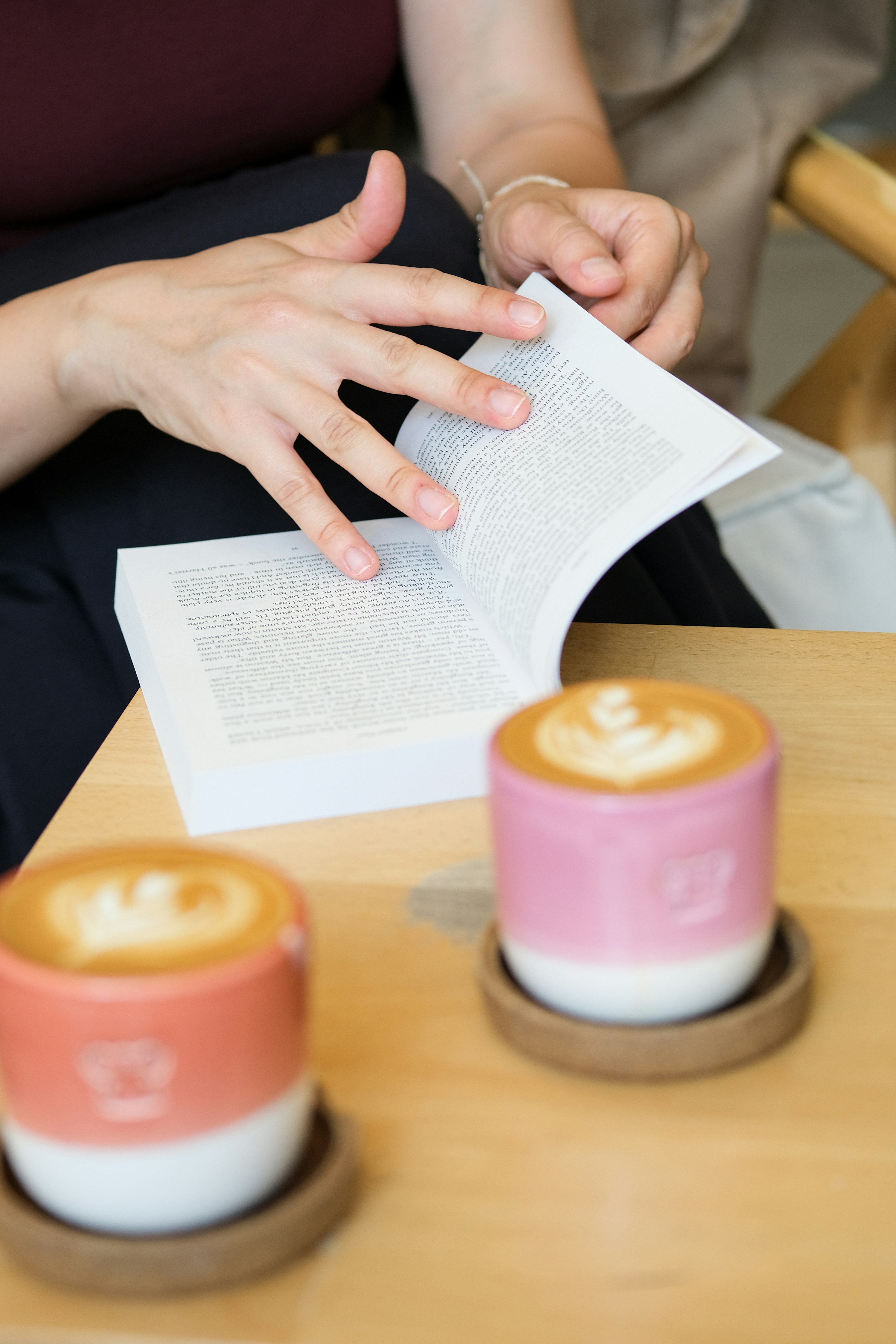 Hands Turn Pages: Quiet Moment with a Story and Latte