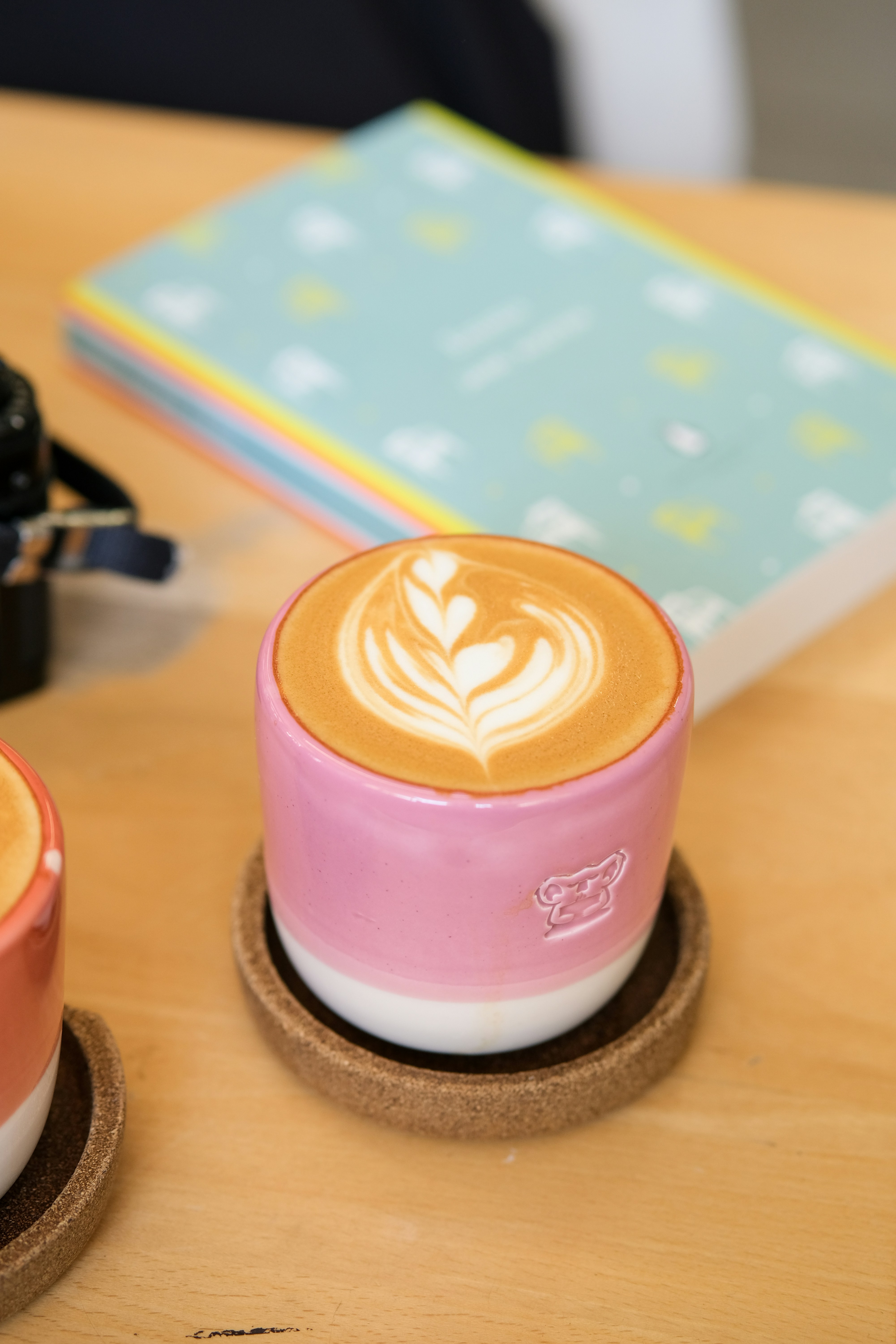 Pink Ceramic Latte Sculpture on a Wooden Table