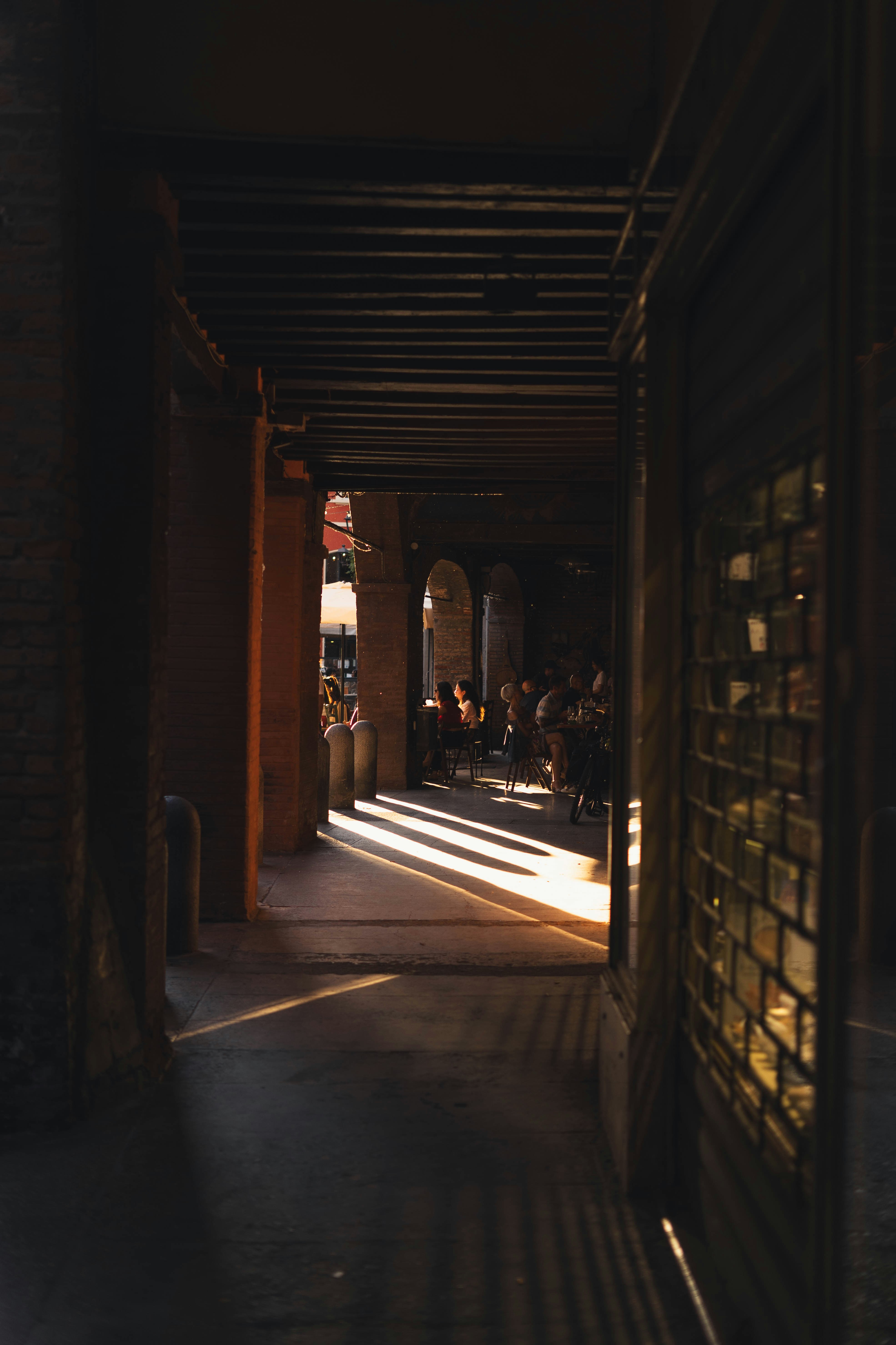 Sunlit Alley Café: Peoples and Patterns in a Shadowed Arcade