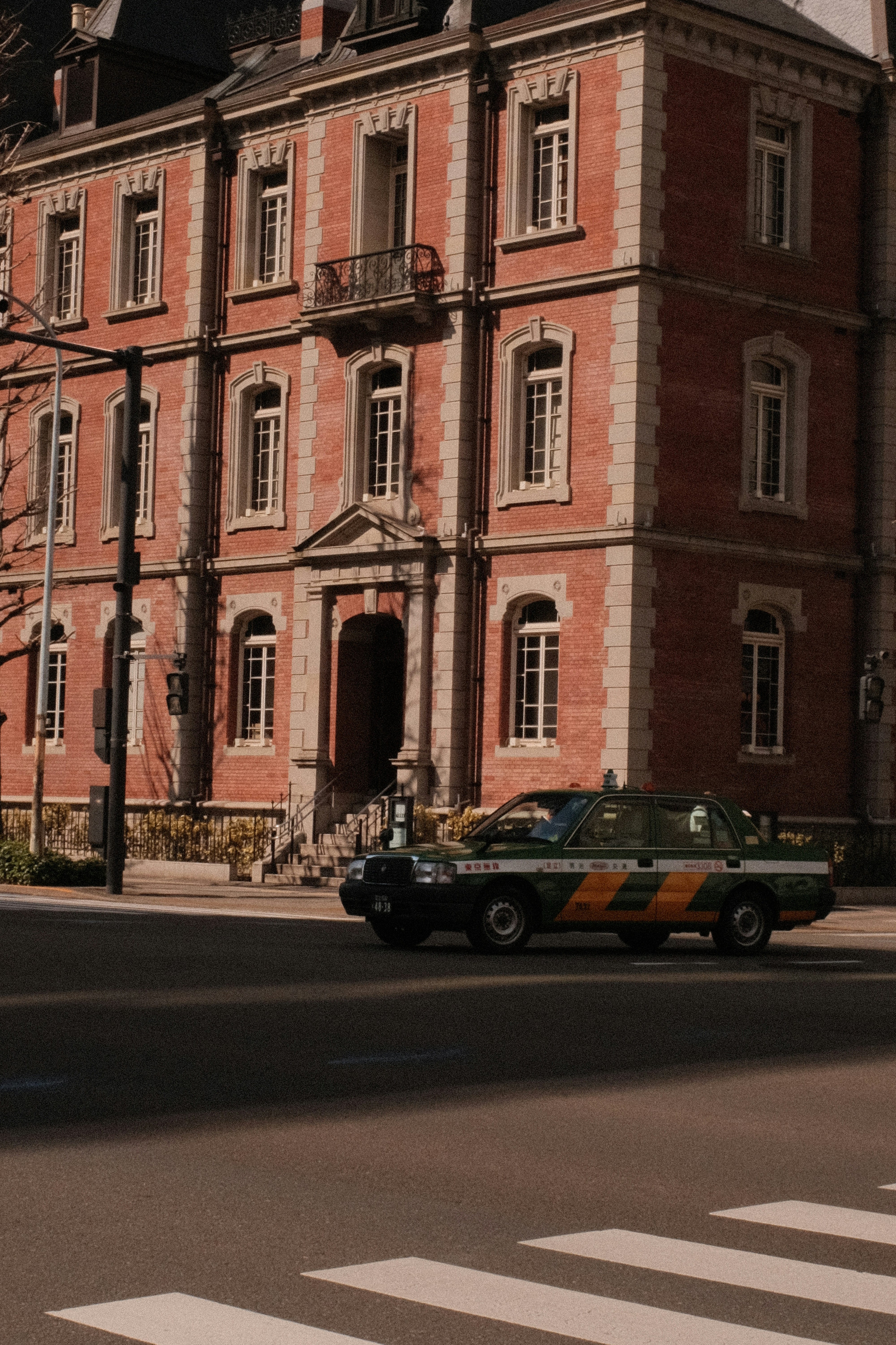 Brick Facade, Green Taxi, and City Crossing