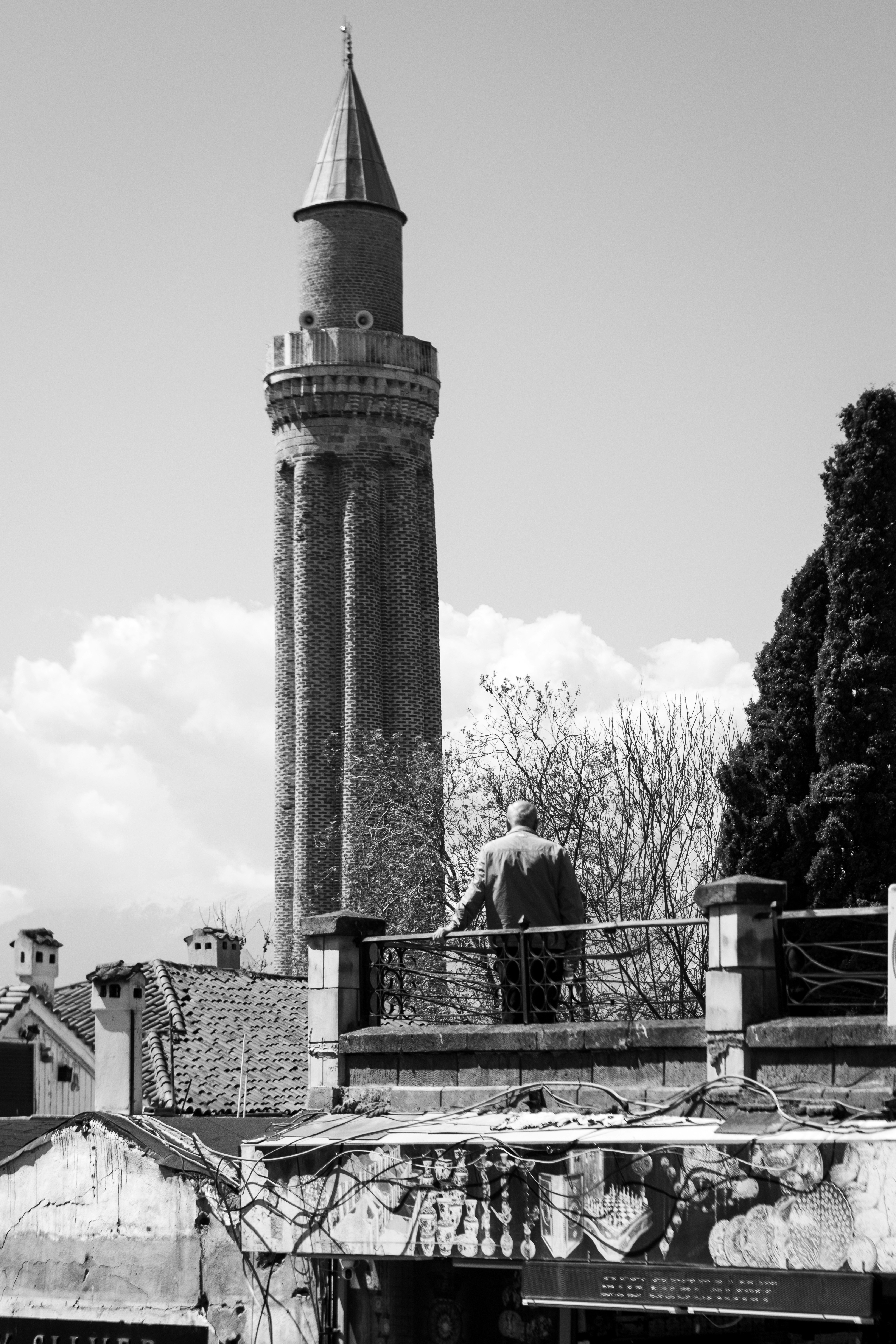 Towering Echo: A Pensive Figure Beside the Brick Spire
