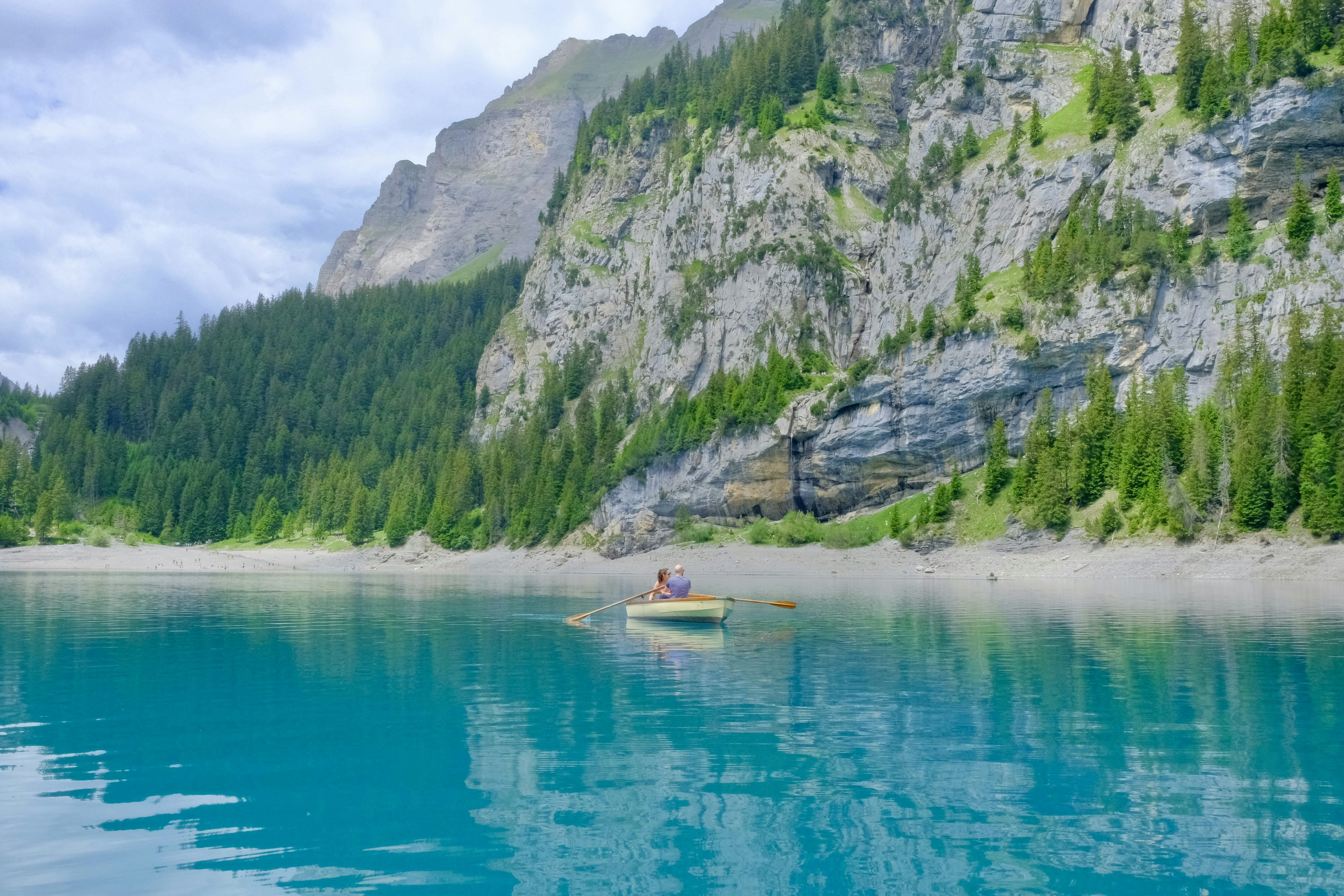 Emerald Lake Fisher: A lone boat at the base of towering limestone cliffs