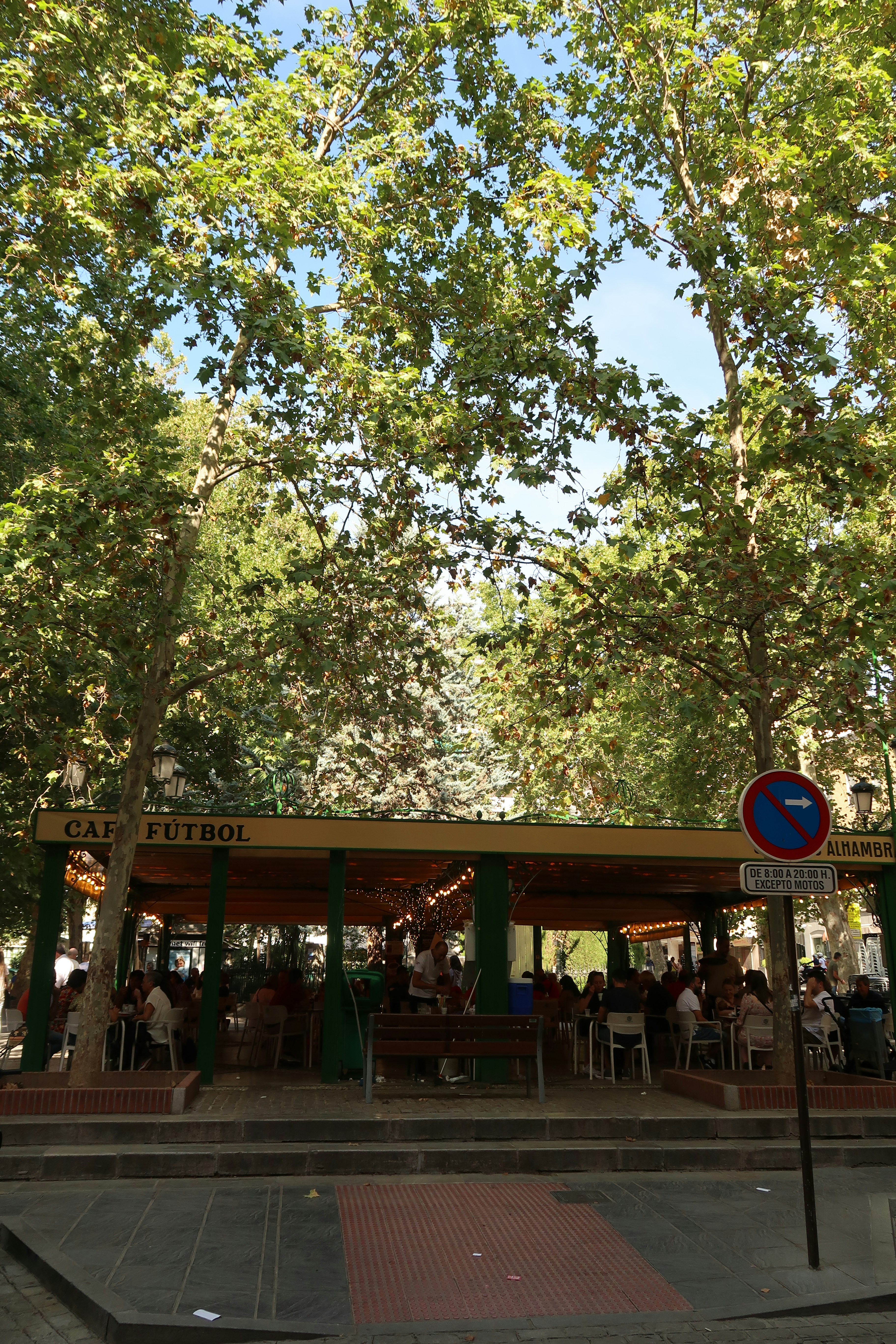 Shaded cafe at the edge of a sunlit plaza