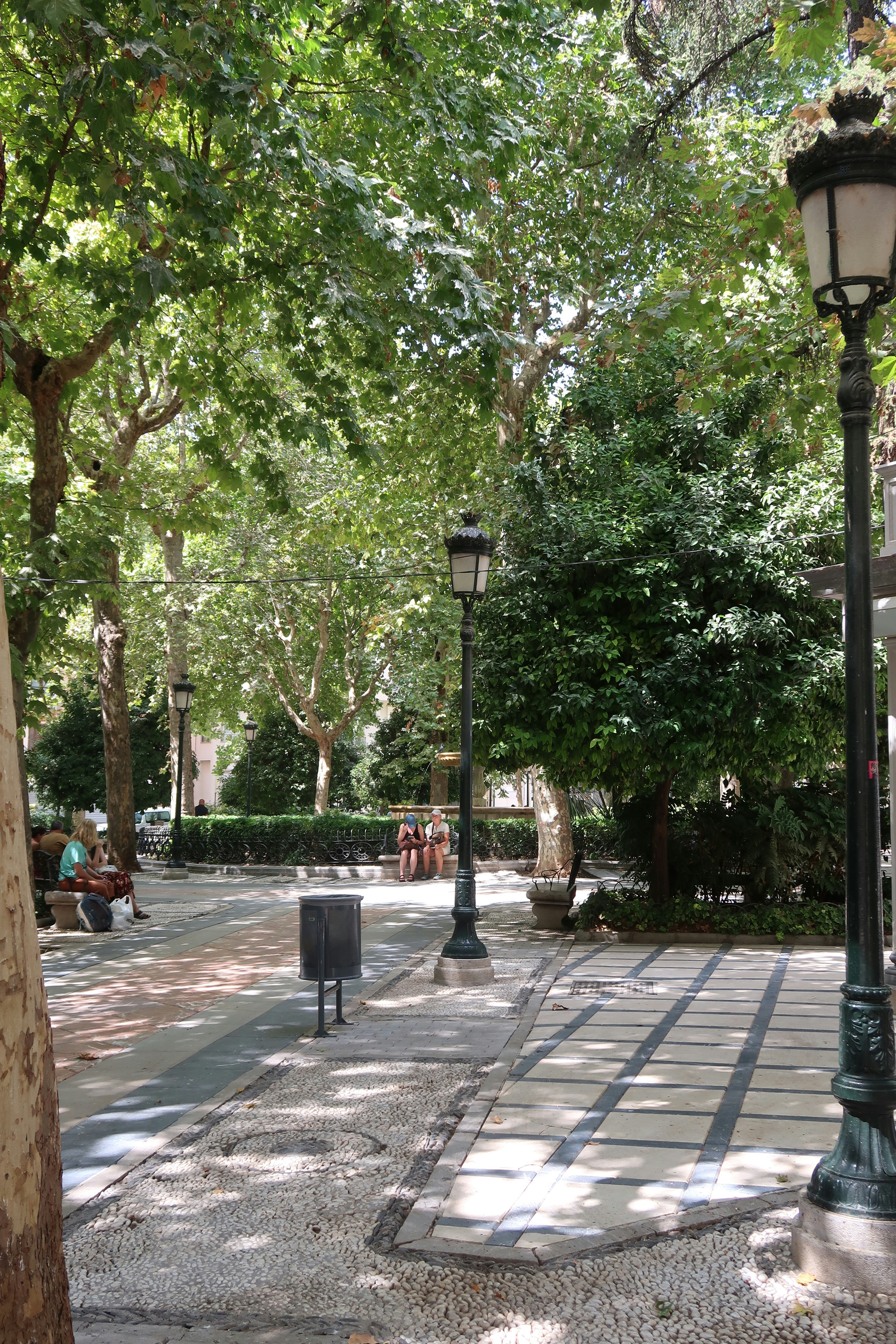 Quiet Plaza with Shaded Path and Vintage Lamp Posts