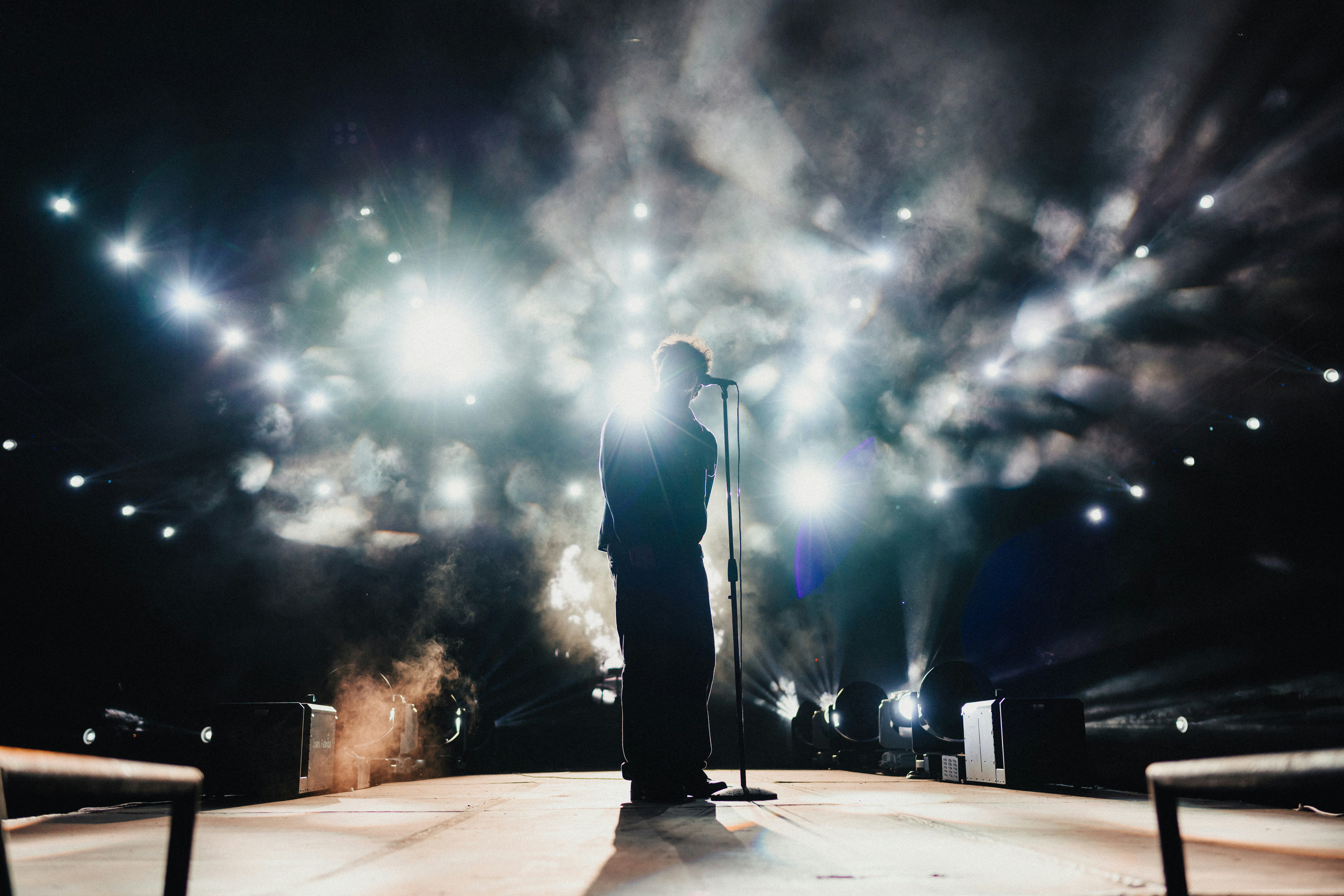 Backlit silhouette at center stage under a chorus of lights