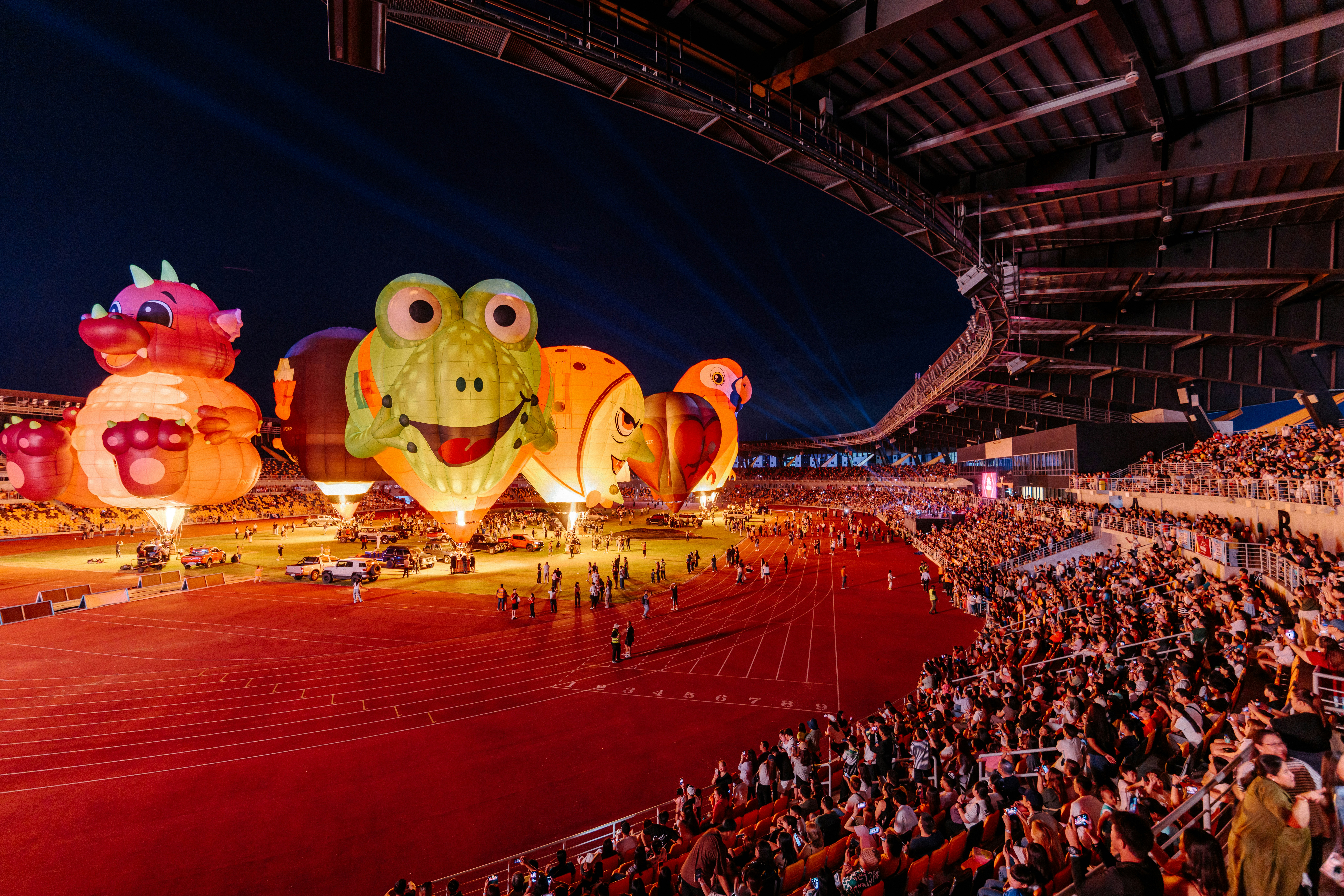 Night of Giant Balloons Illuminates a Packed Stadium Runway