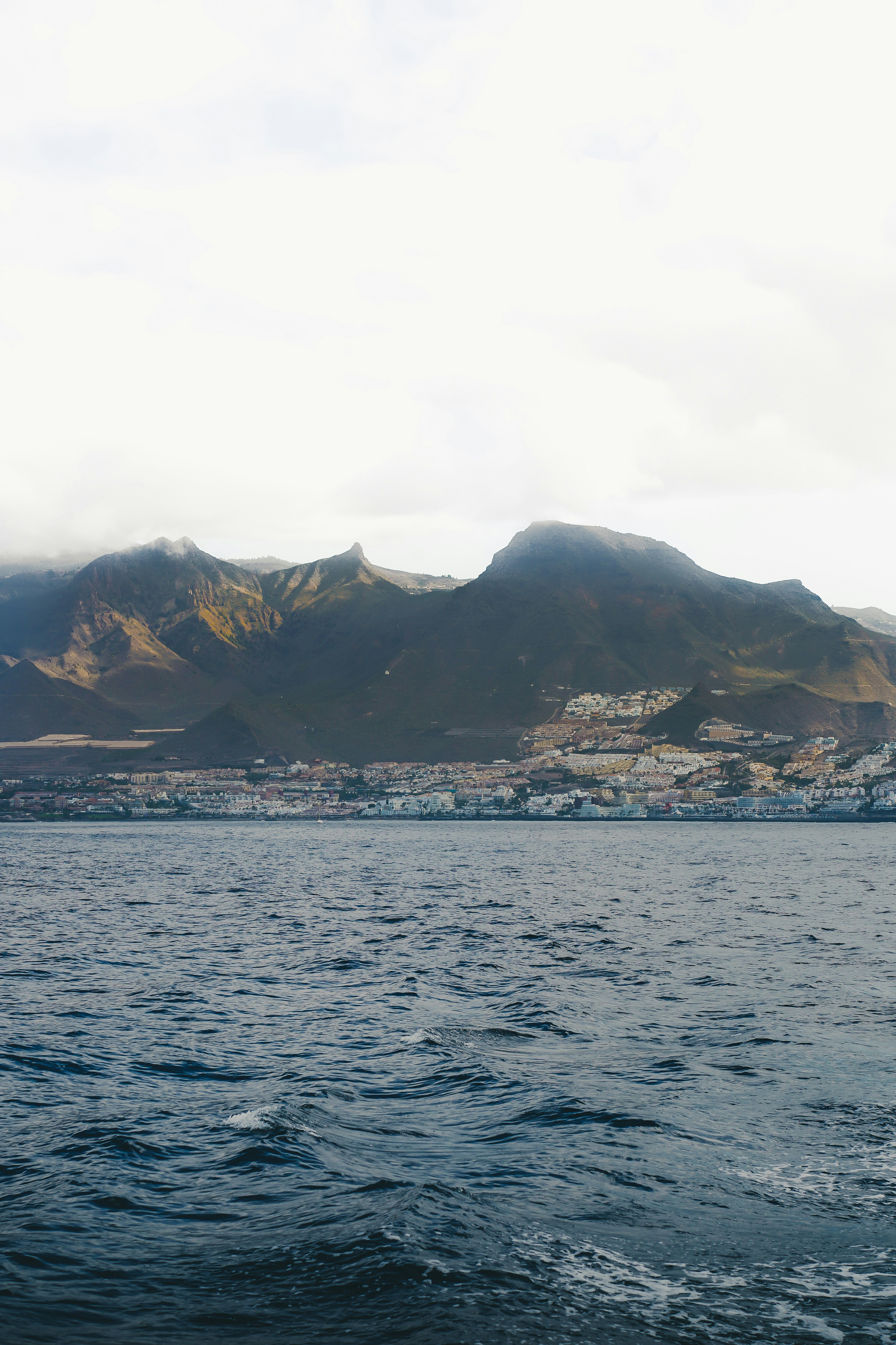 Coastal Horizon: Gentle Waves Against a Mountain Rim