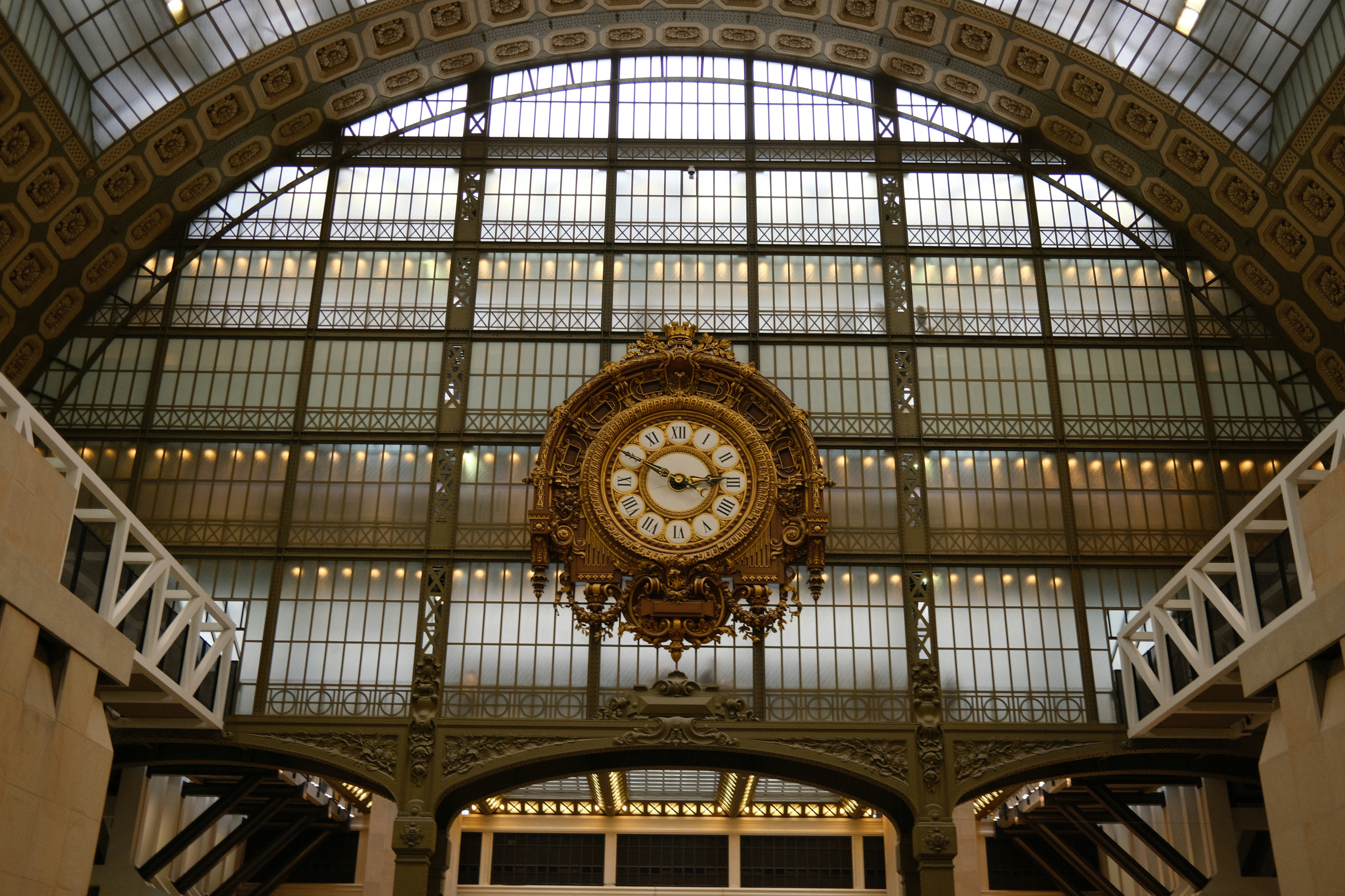 Ornate Master Clock Centerpiece under a Glass Arch