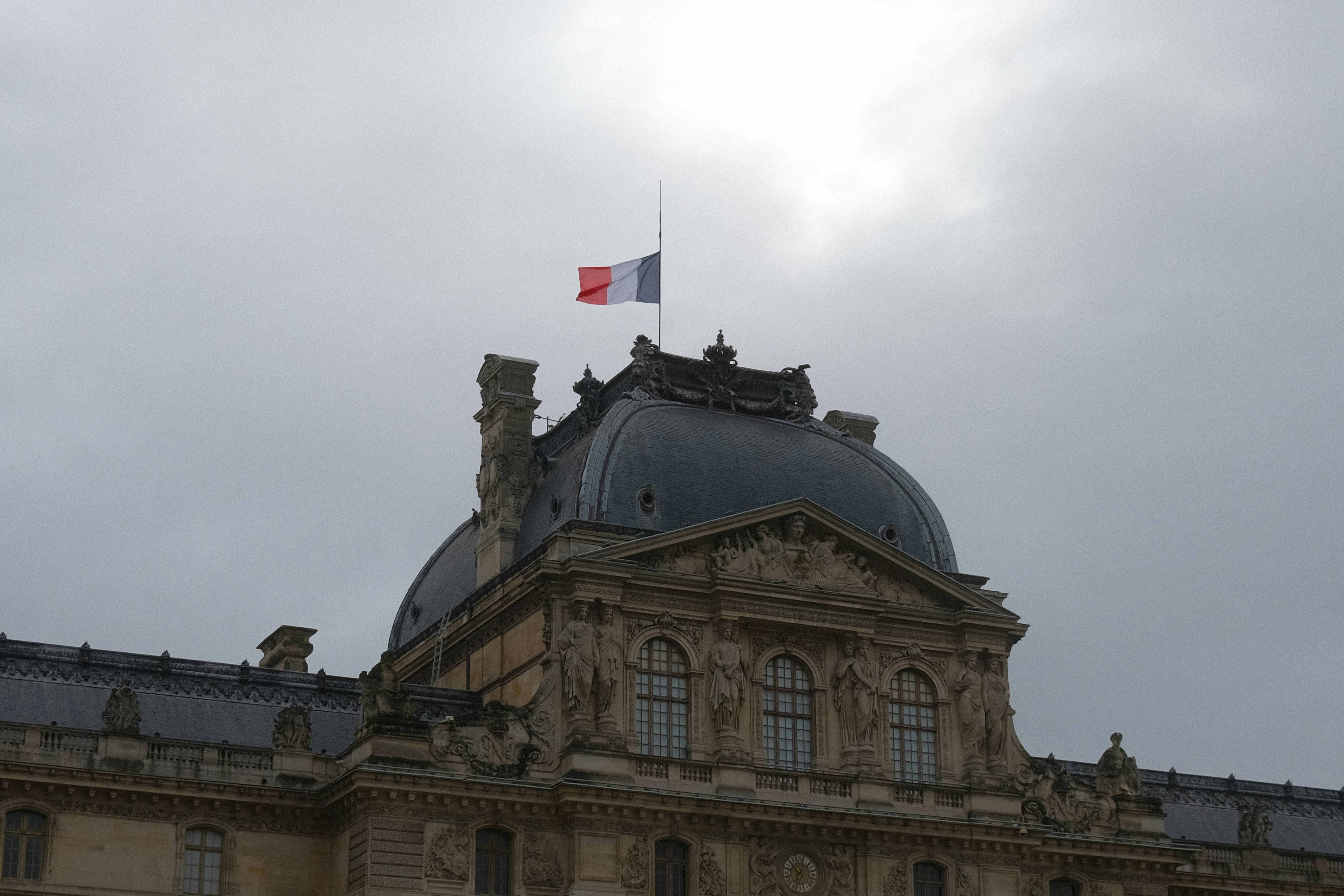 Flag Above the Historic Facade: A Dusk Over the Louvre-style Dome