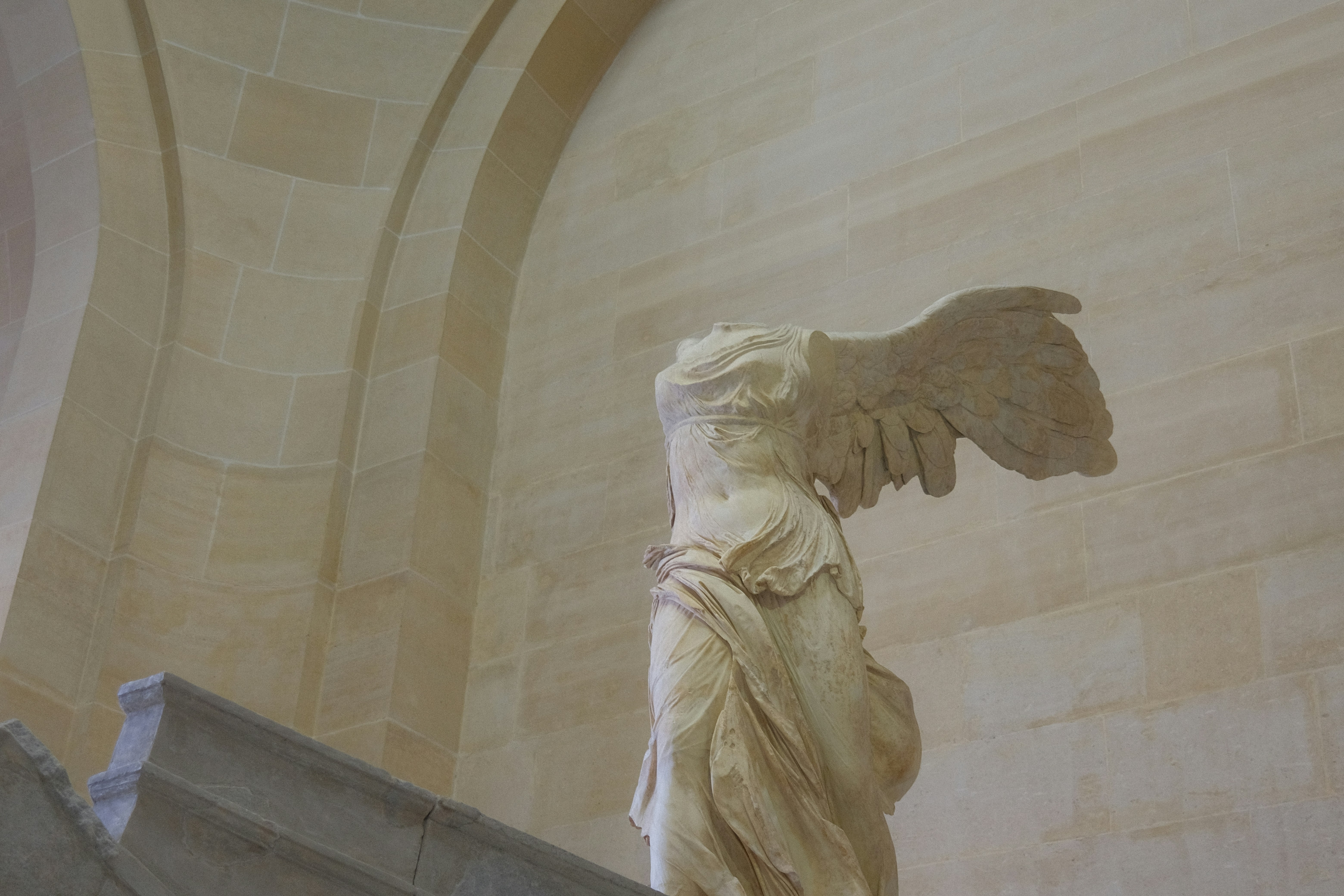 Winged Marble Vigil in a sunlit Archway