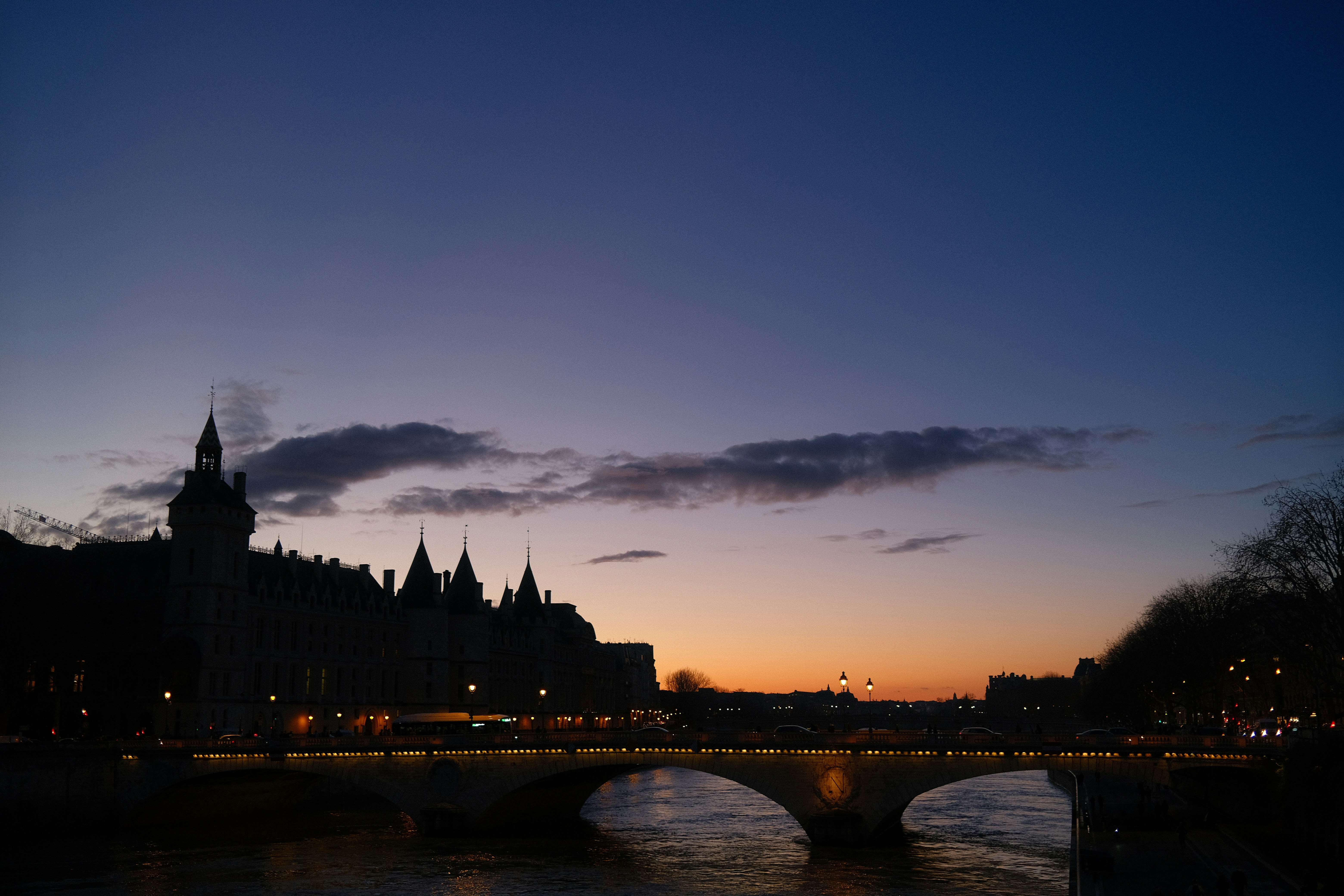 Twilight Silhouette Over the River with Arched Bridge