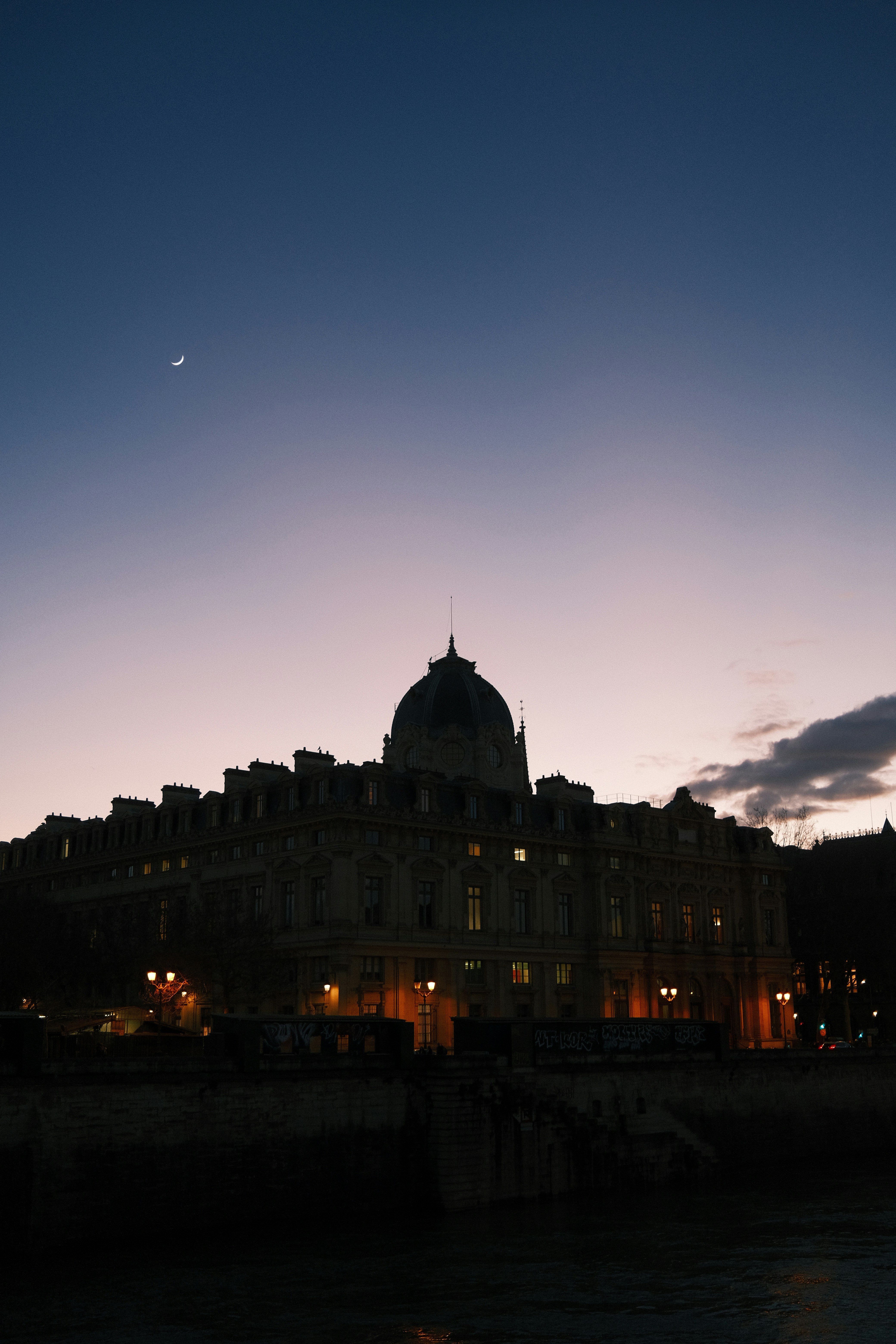 Dusk on the Seine: The silhouette of a grand riverfront palace against a gradient sky