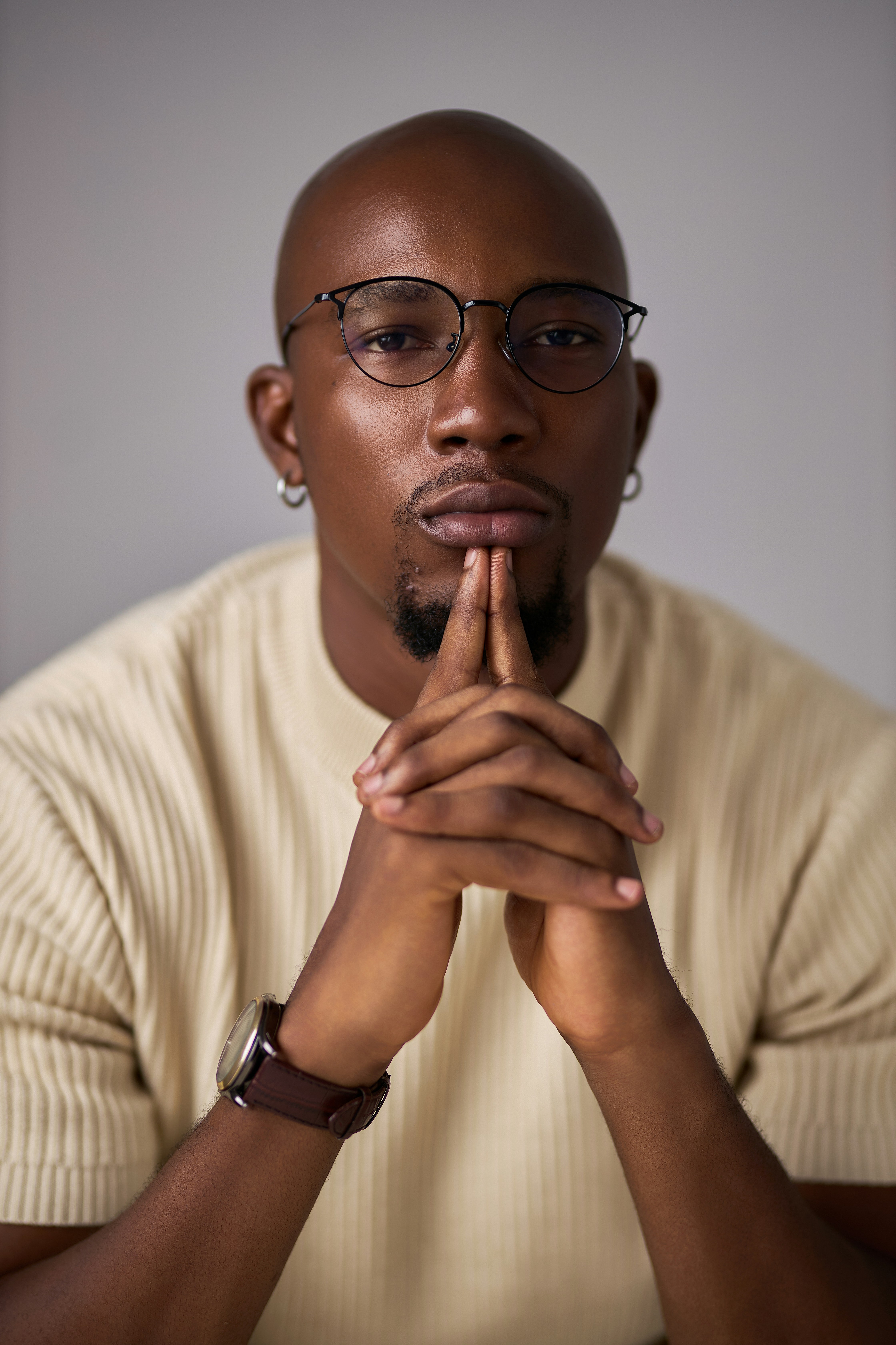 Contemplative Gaze: A Quiet Moment with Hands Steepled
