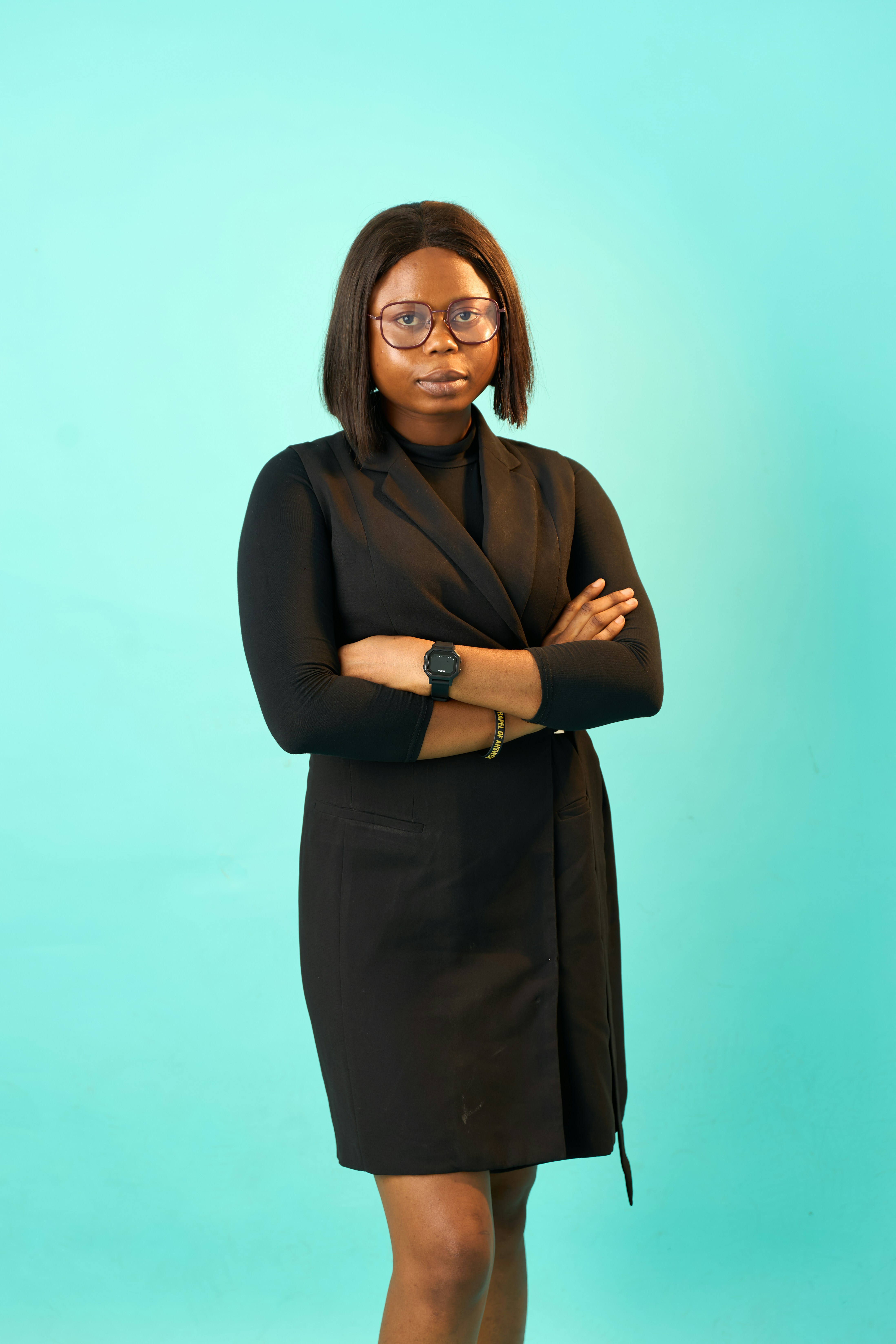  poised professional in a black blazer against turquoise backdrop
