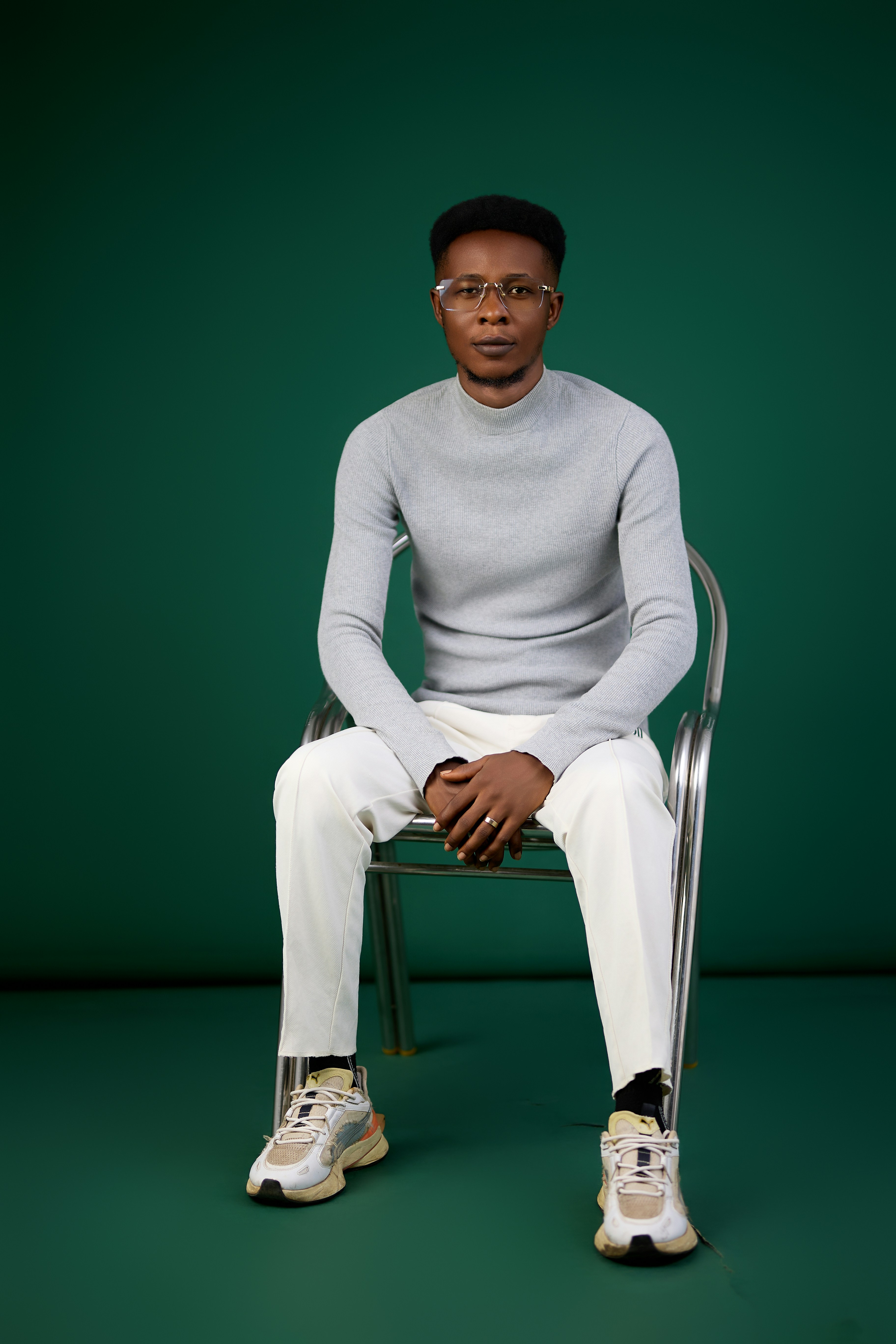 Gentleman in a Quiet Studio: Minimalist Pose, Rich Green Backdrop