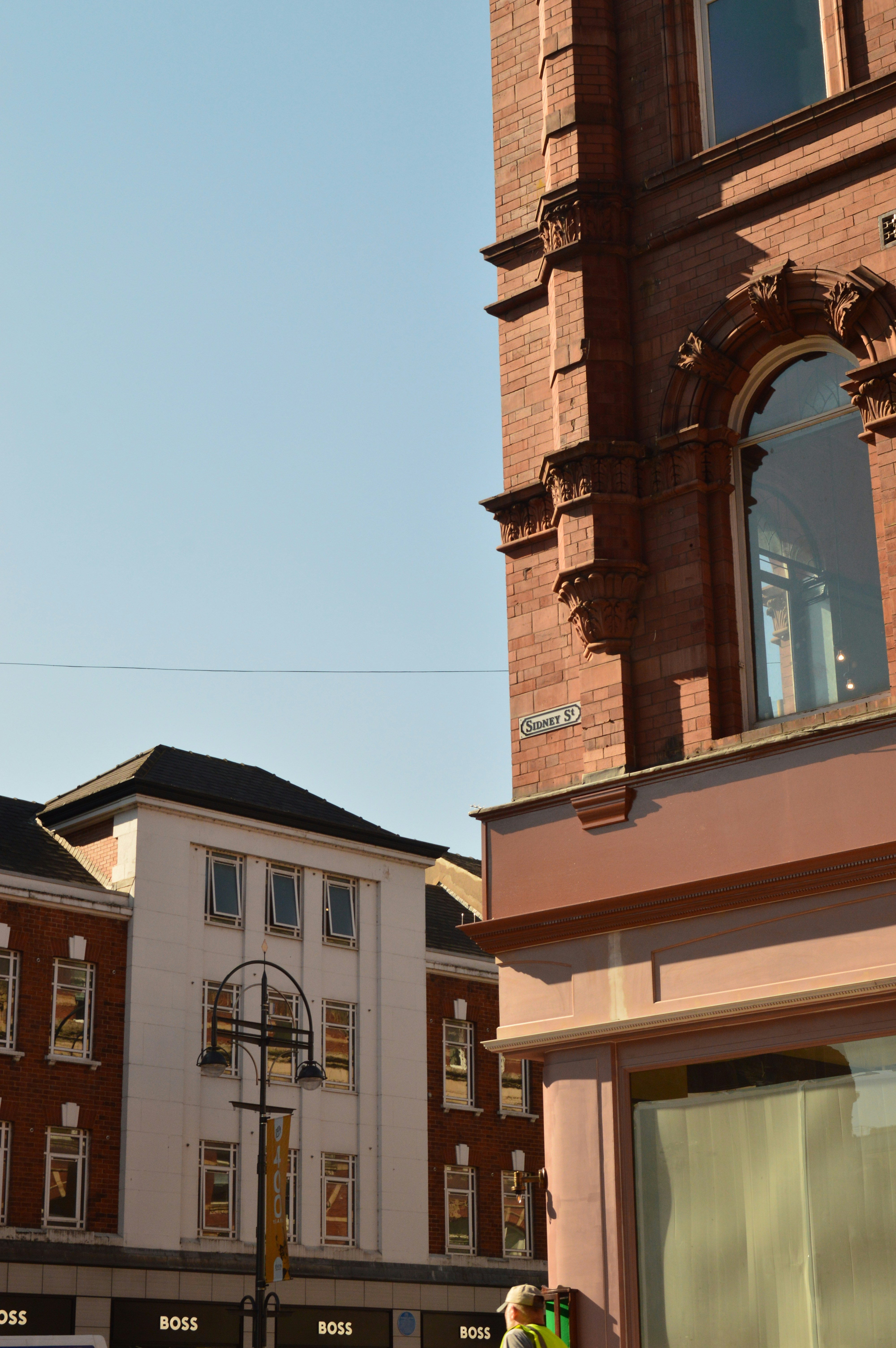 Brick Corner: A Sunlit Facade and Shopfront Corner