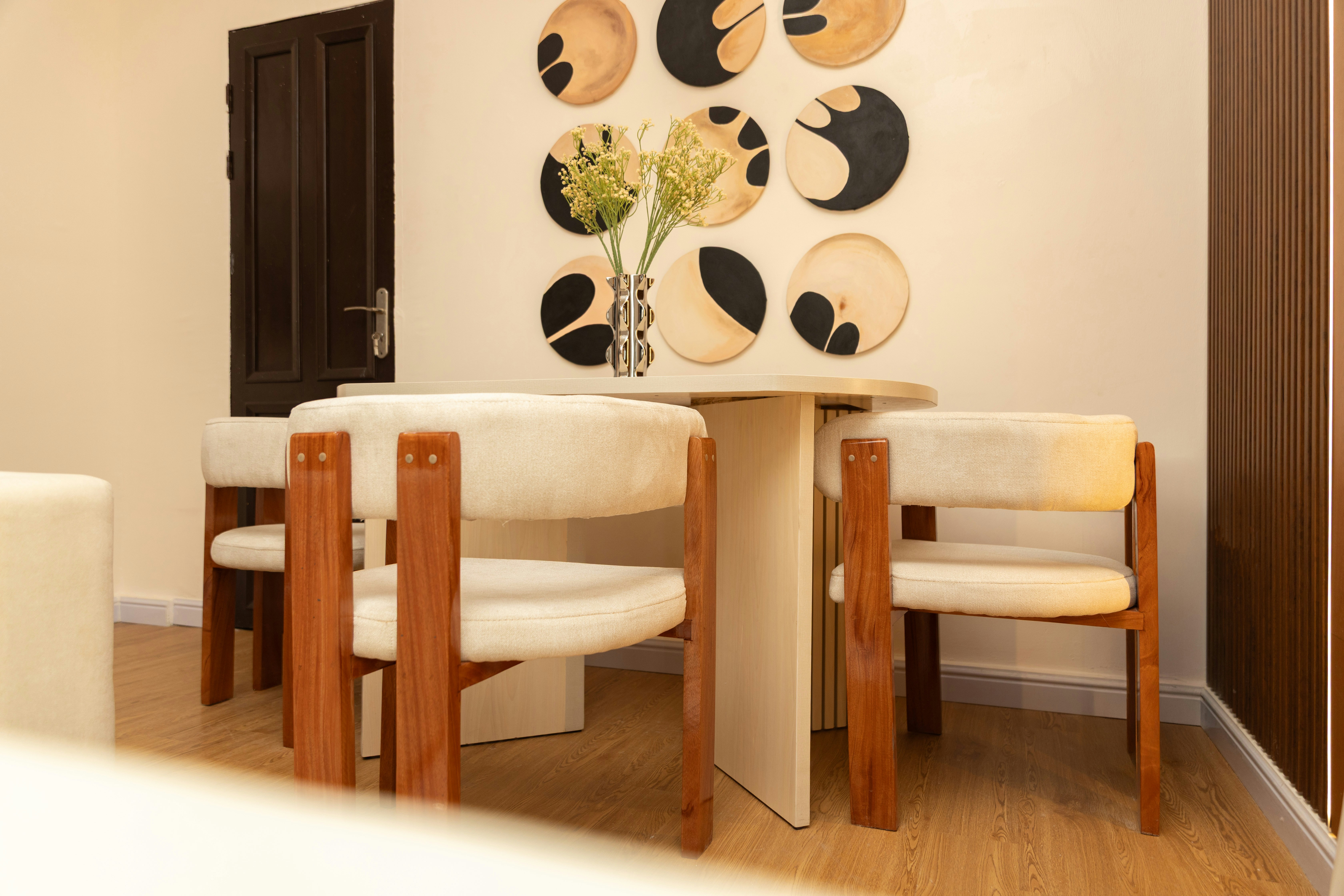 Modern dining area with round table, chairs, and wall art - Free Photo ...
