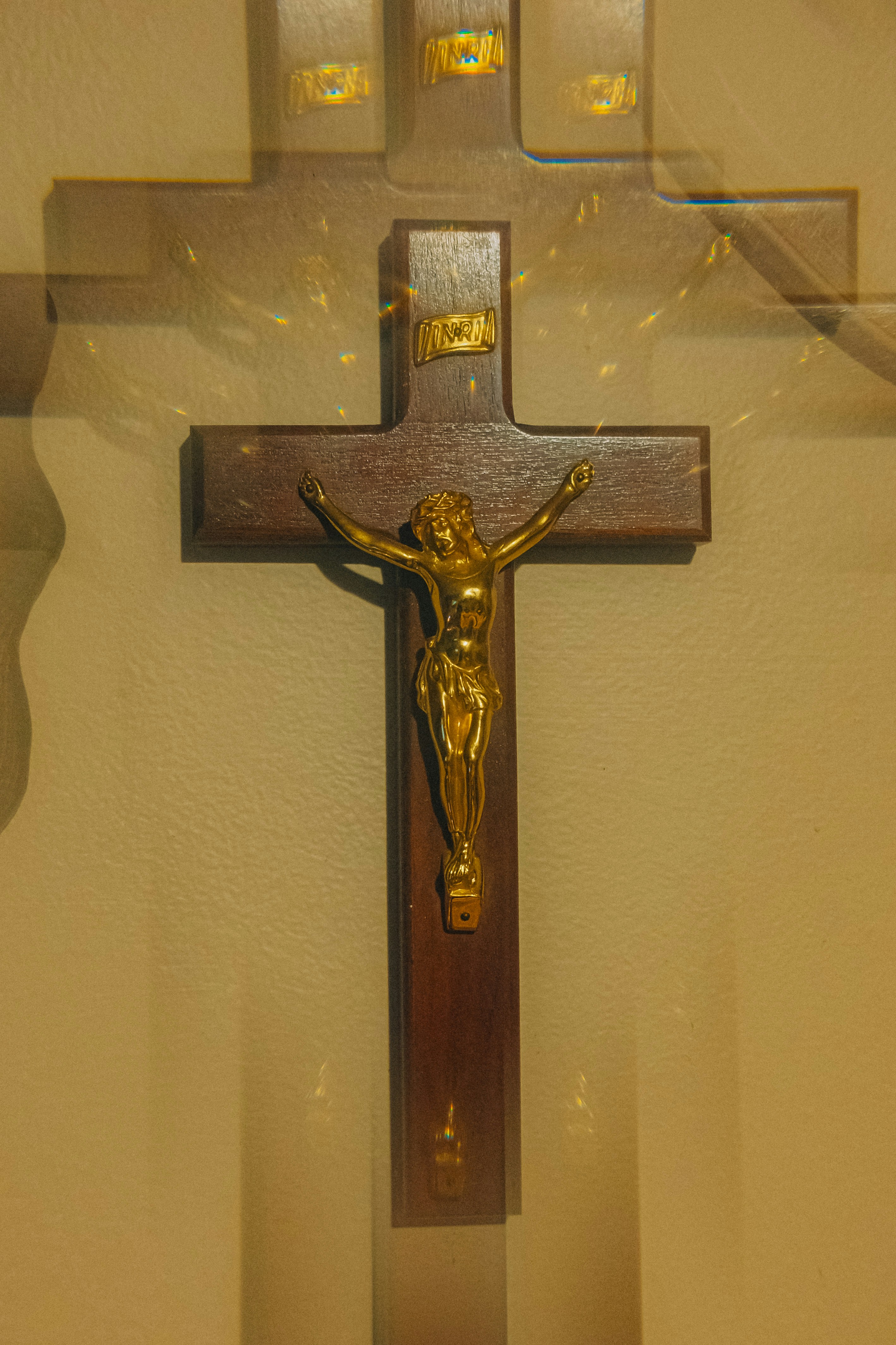Crucifix in warm glow: a golden figure against a wooden cross